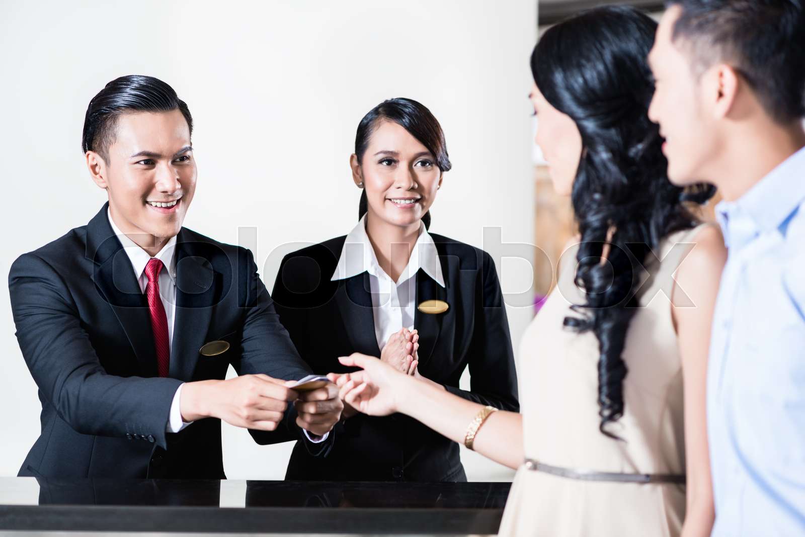 Employees of a hotel welcomes young couple | Stock image | Colourbox