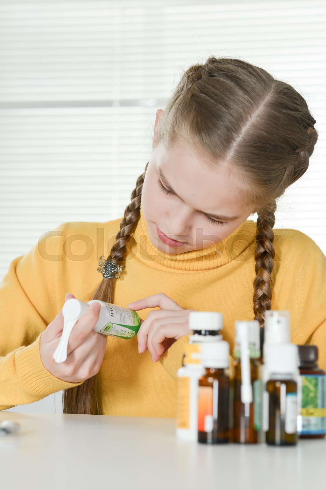 Portrait of a cute little girl taking medicine at home | Stock image ...