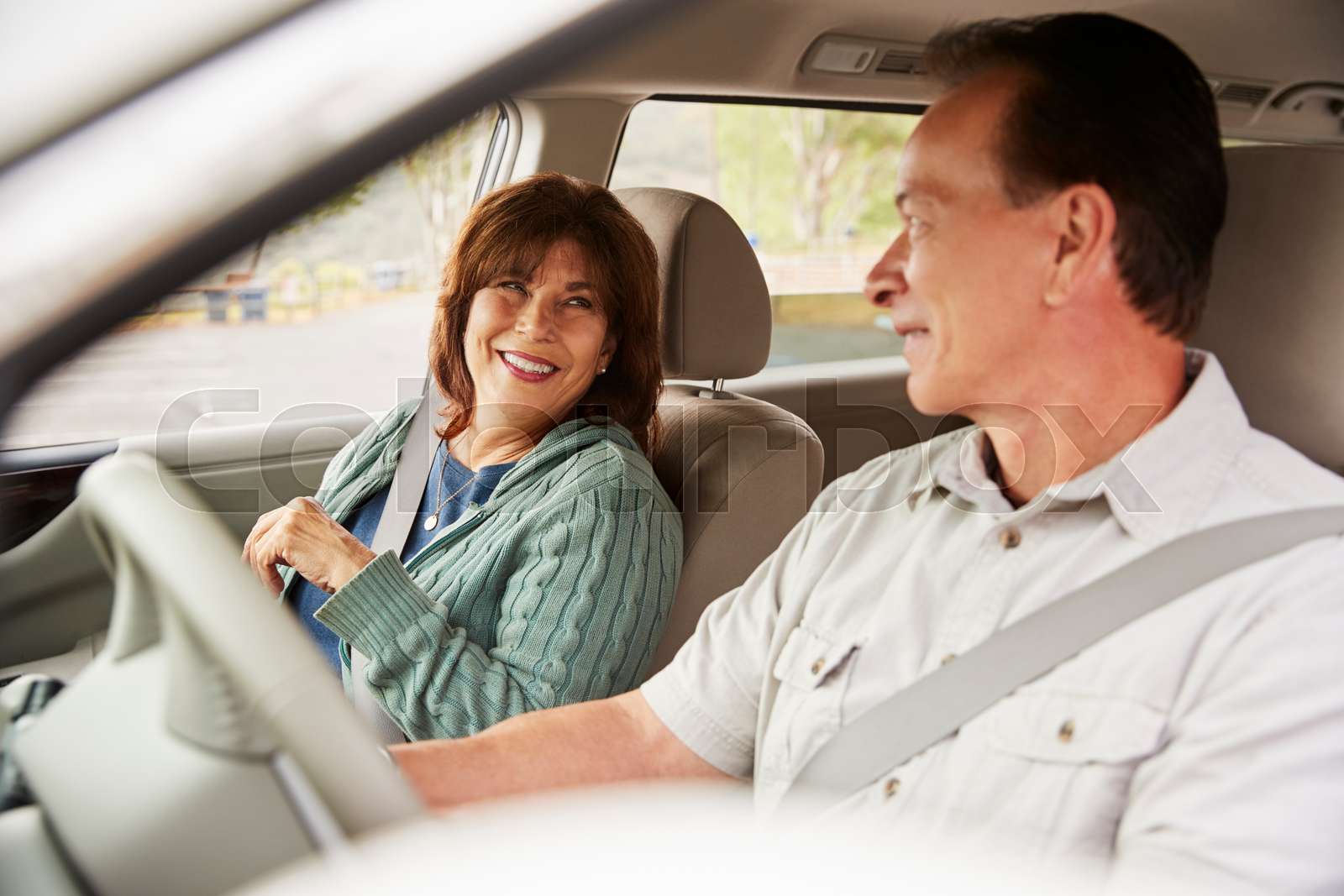 Senior mixed race couple in car going on holiday | Stock image | Colourbox