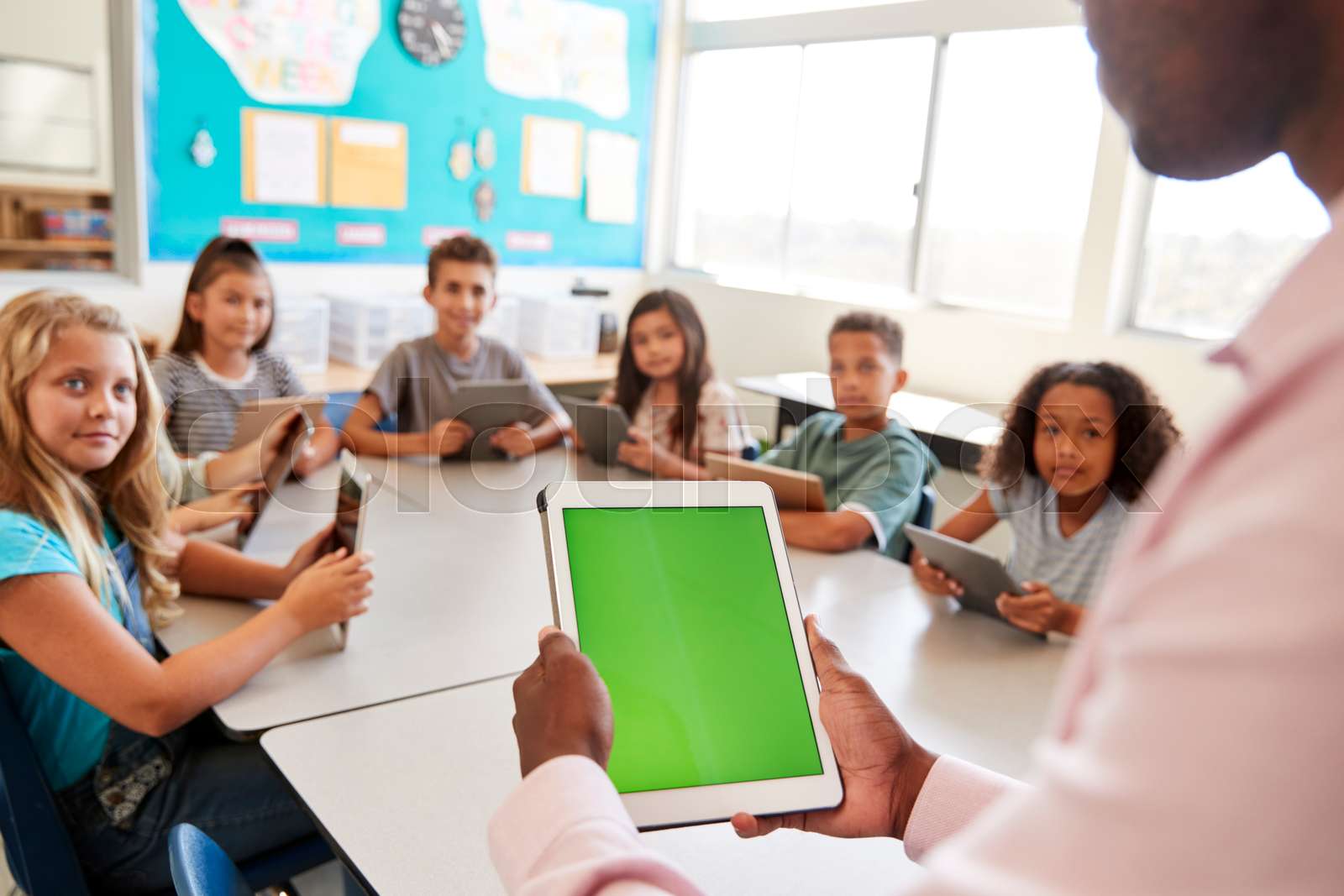 Teacher and kids using tablets in elementary school lesson | Stock ...