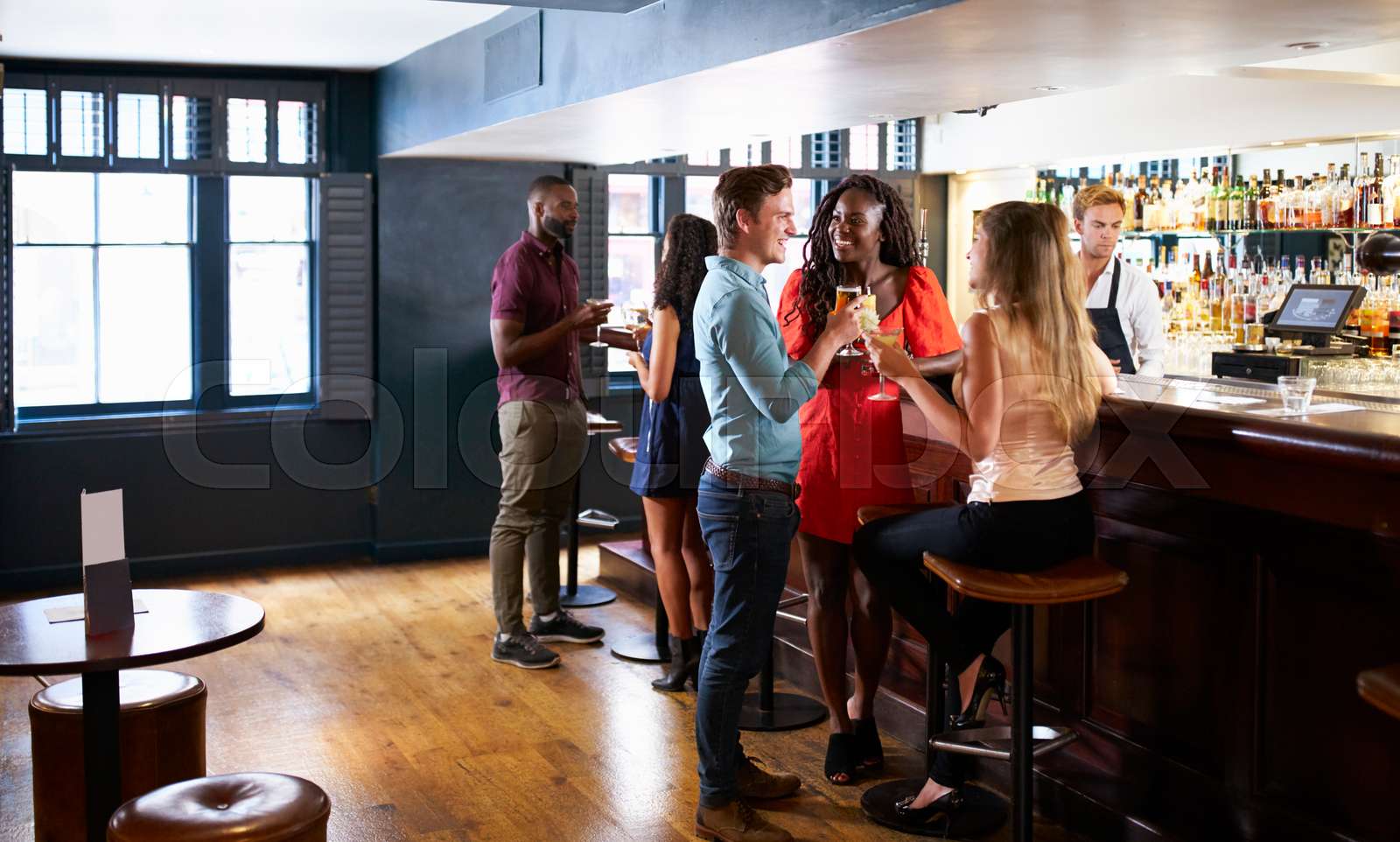 Group Of Young Friends Relaxing In Bar Standing At Counter | Stock ...