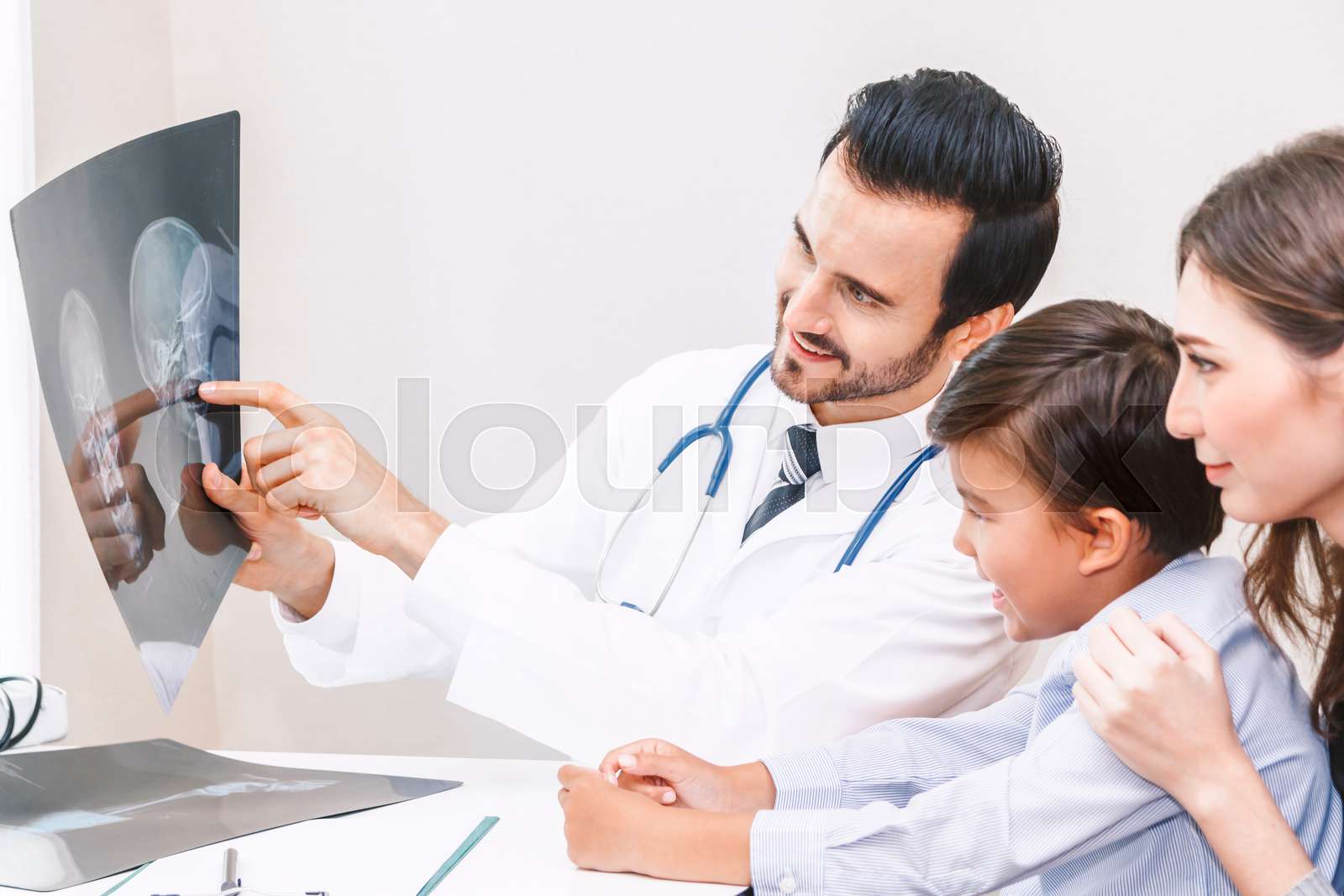 Doctor showing the X-ray photo to little boy in hospital.healthcare and ...