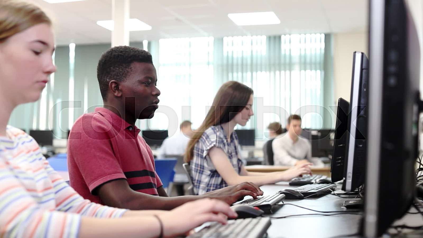 Teacher Helping Male High School Student Working In Computer Class ...
