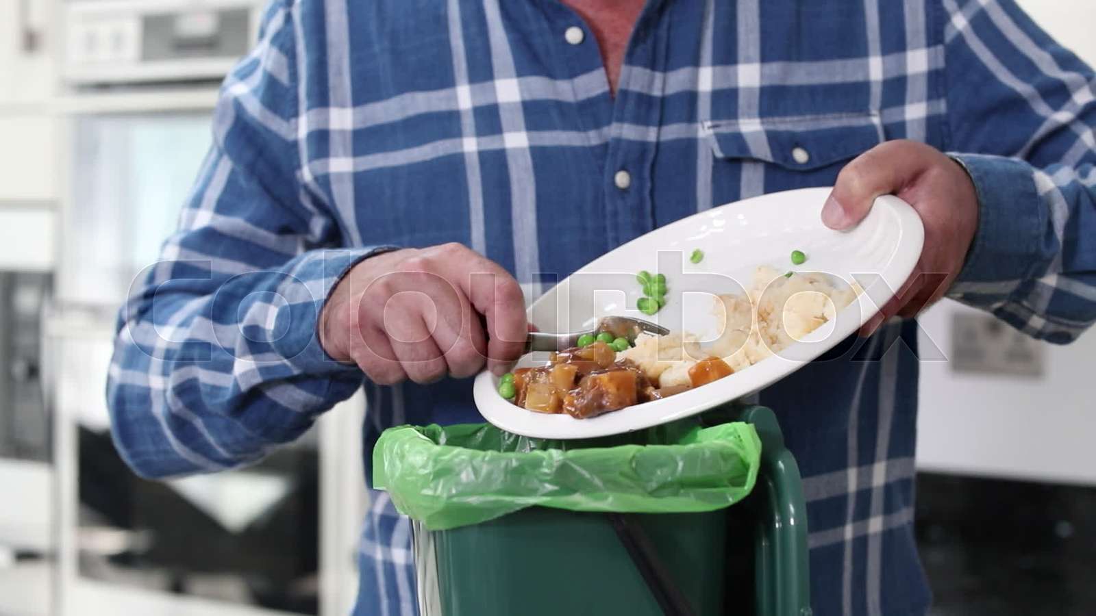 Man Scraping Food Leftovers Into Garbage Bin | Stock video | Colourbox