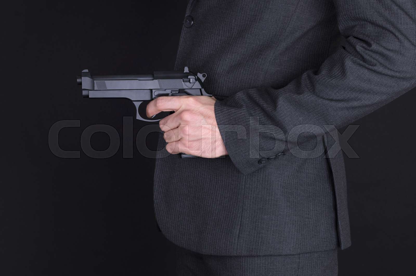 Man in suit with gun | Stock image | Colourbox