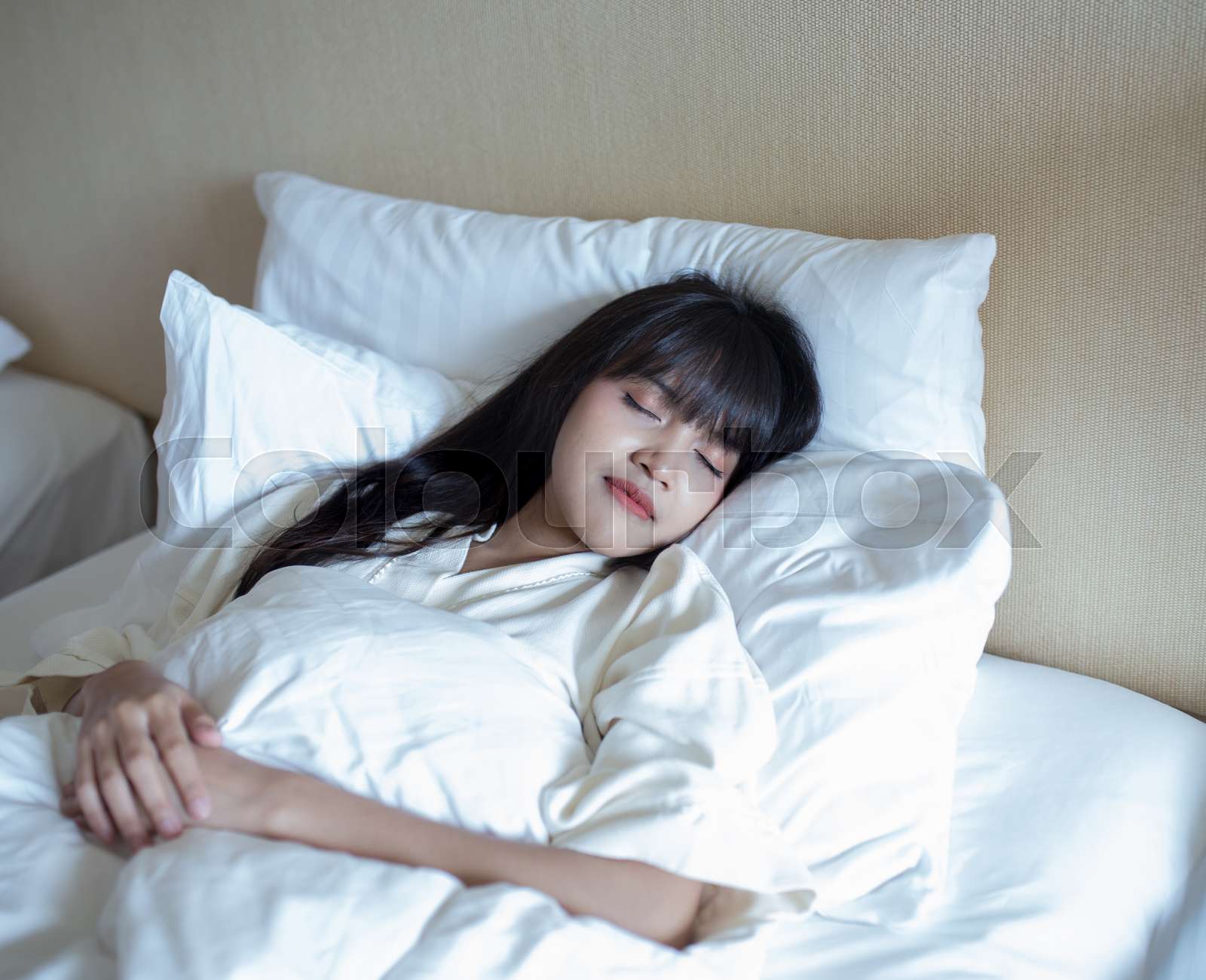 Young beautiful girl sleeping happily on her bed | Stock image | Colourbox