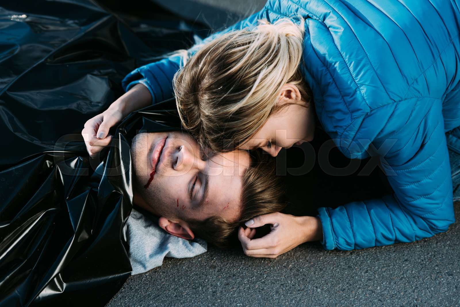 young woman crying and hugging dead man on road | Stock image | Colourbox