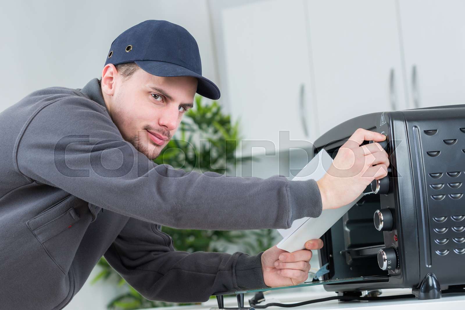 Man setting up appliance | Stock image | Colourbox