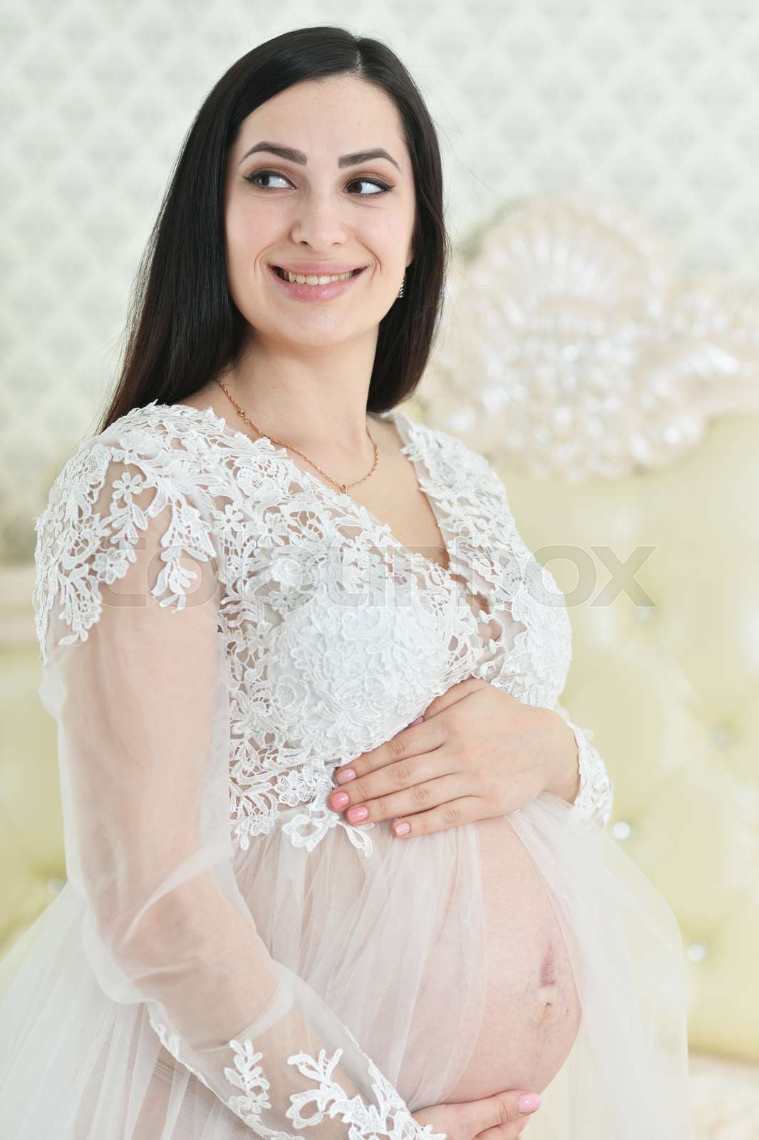 Beautiful young pregnant woman posing on bed | Stock image | Colourbox