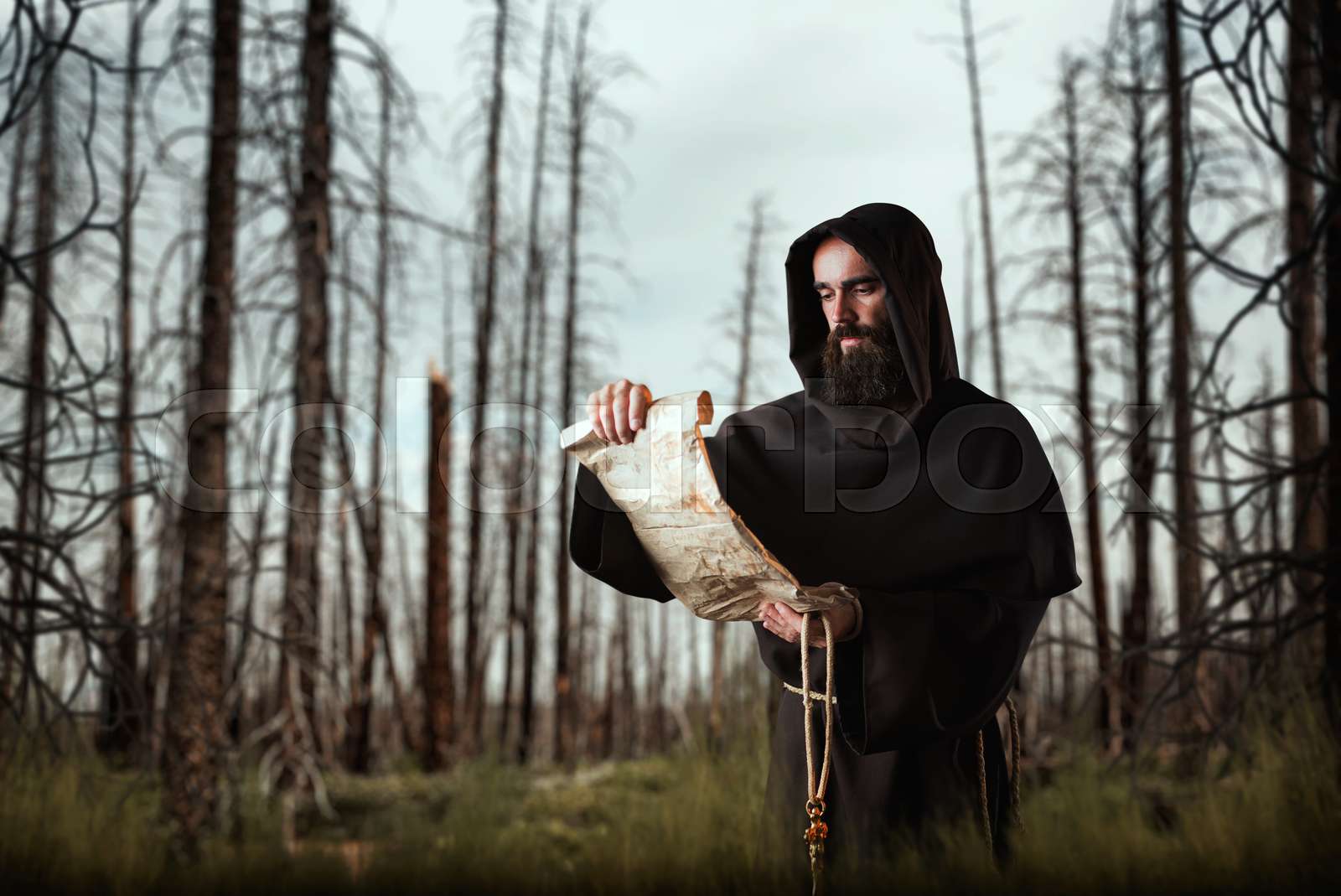 Medieval monk with an evil face reads a prayer | Stock image | Colourbox