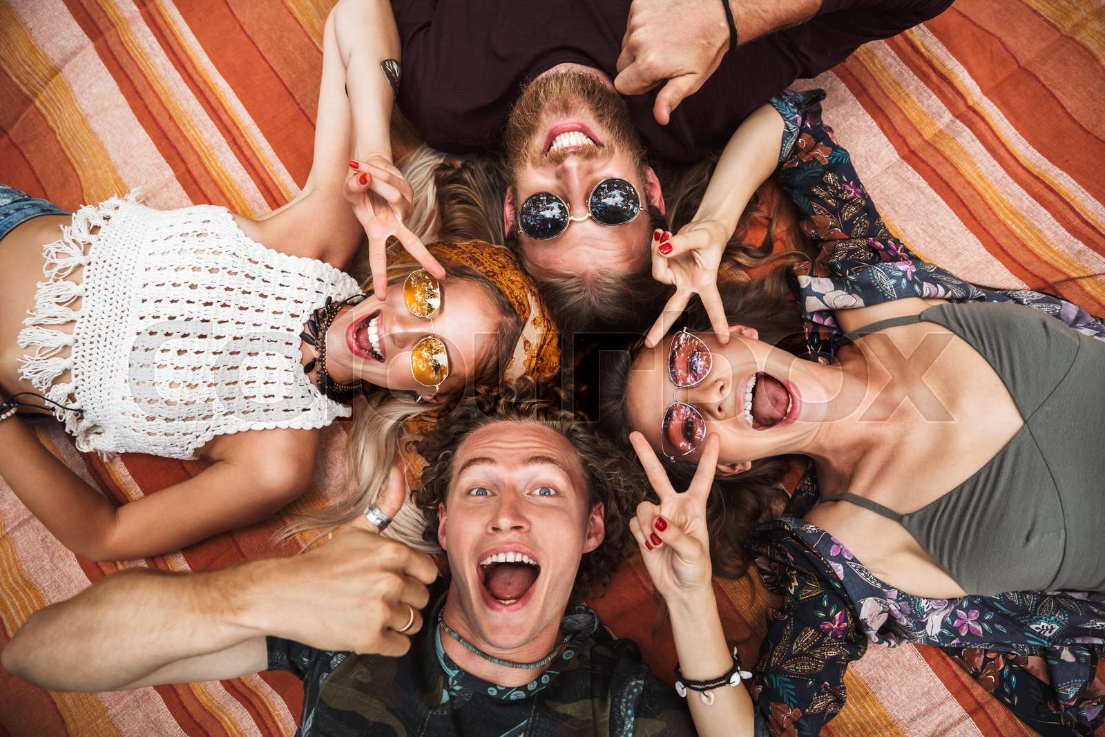 Photo of attractive hippies guys and girls laughing, and lying on ...