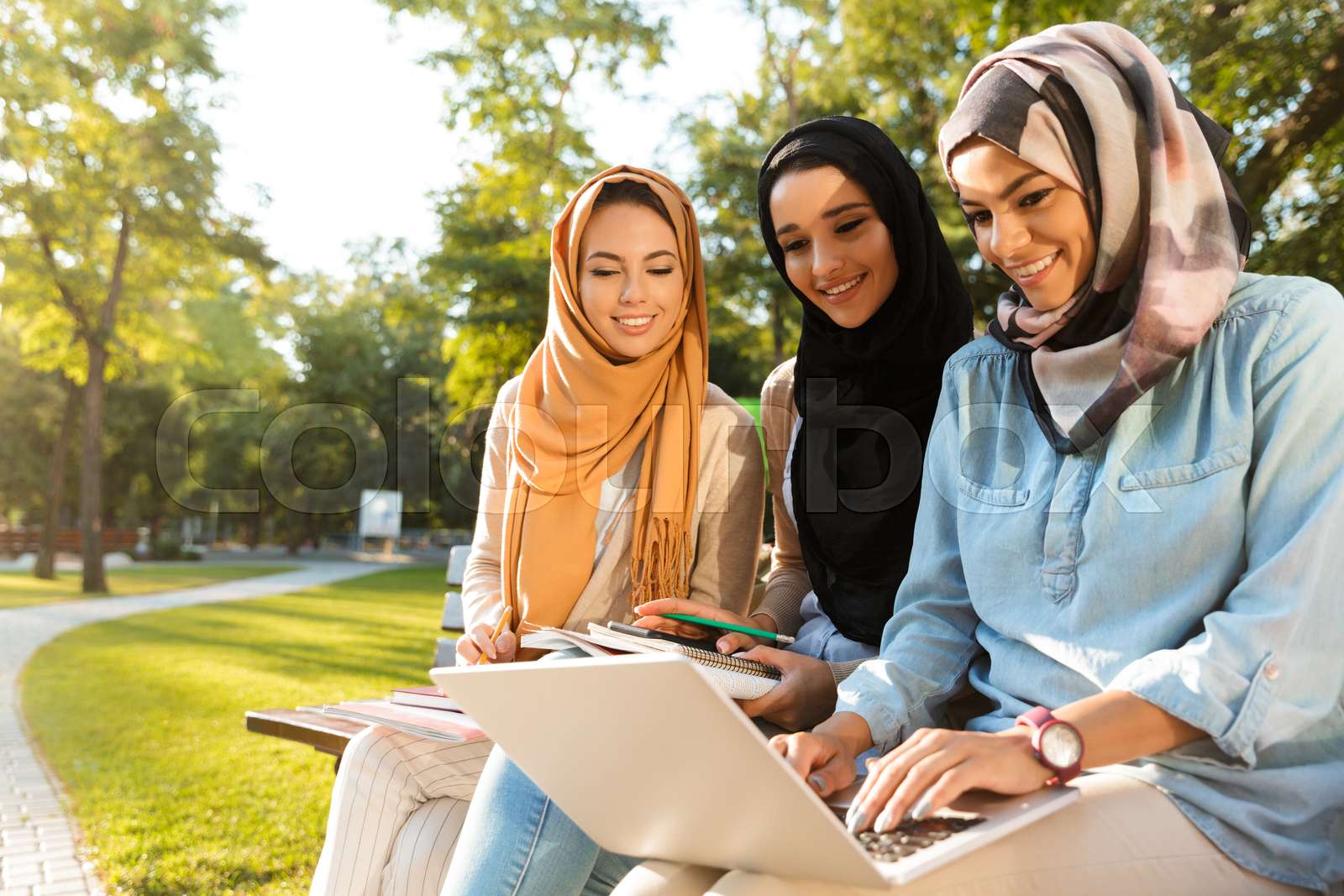 Group of three happy muslim women students | Stock image | Colourbox