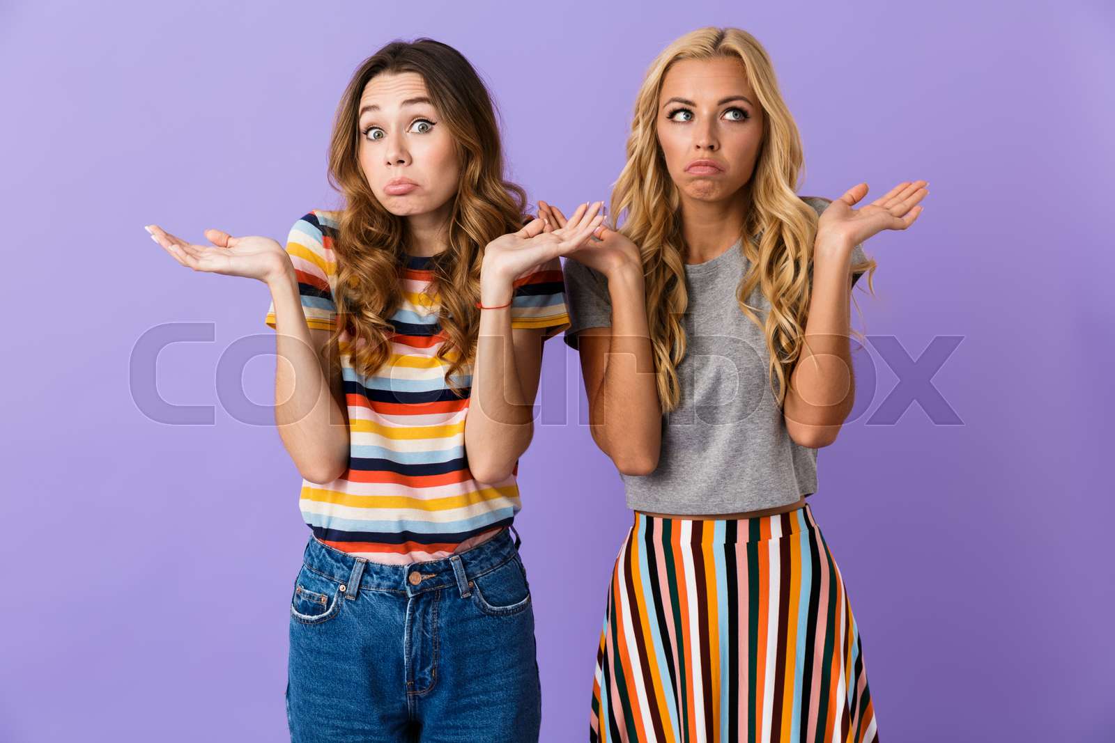 Two pretty confused young girls friends | Stock image | Colourbox