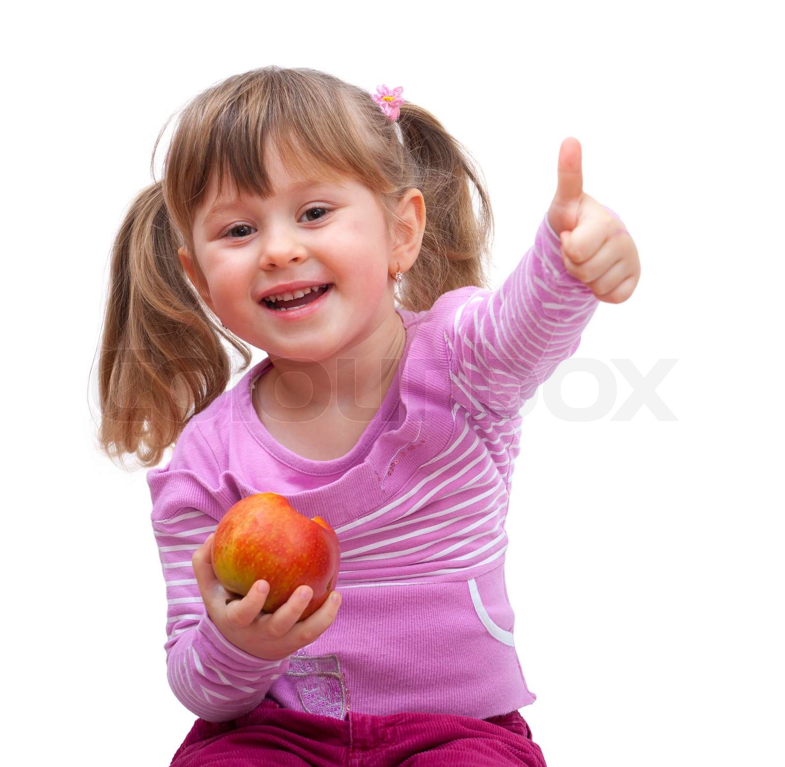 yndig lille pige spiser et æble og vise godt tegn , isoleret mod hvid ...