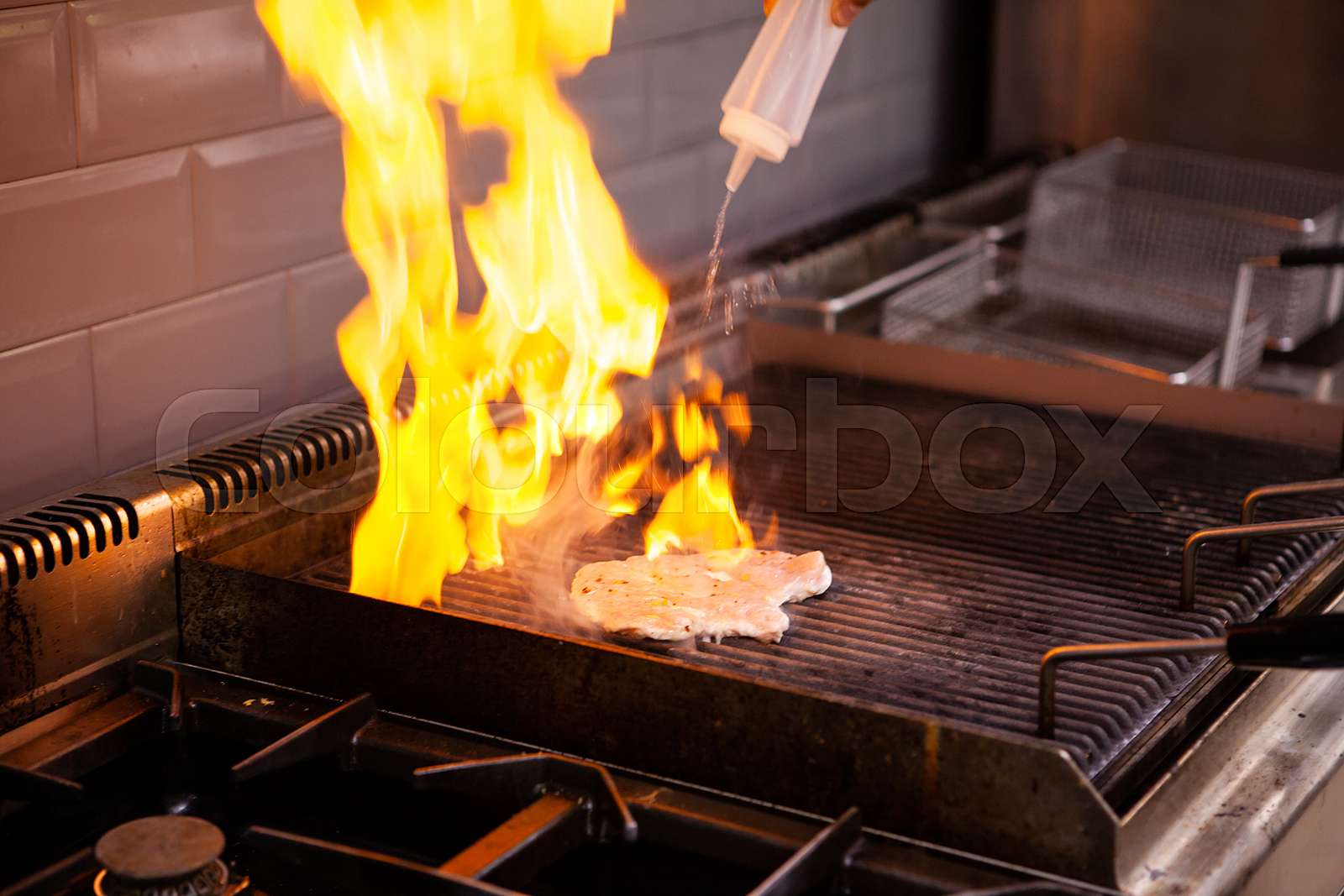 Chef making flambe chicken breast | Stock image | Colourbox