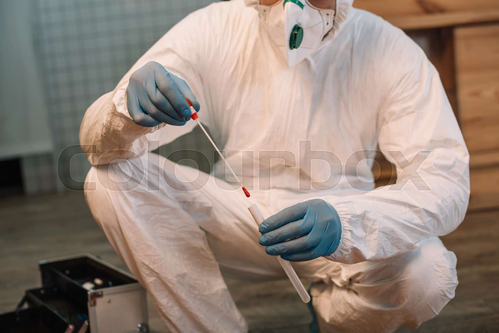 cropped view of forensic investigator in latex gloves taking blood ...