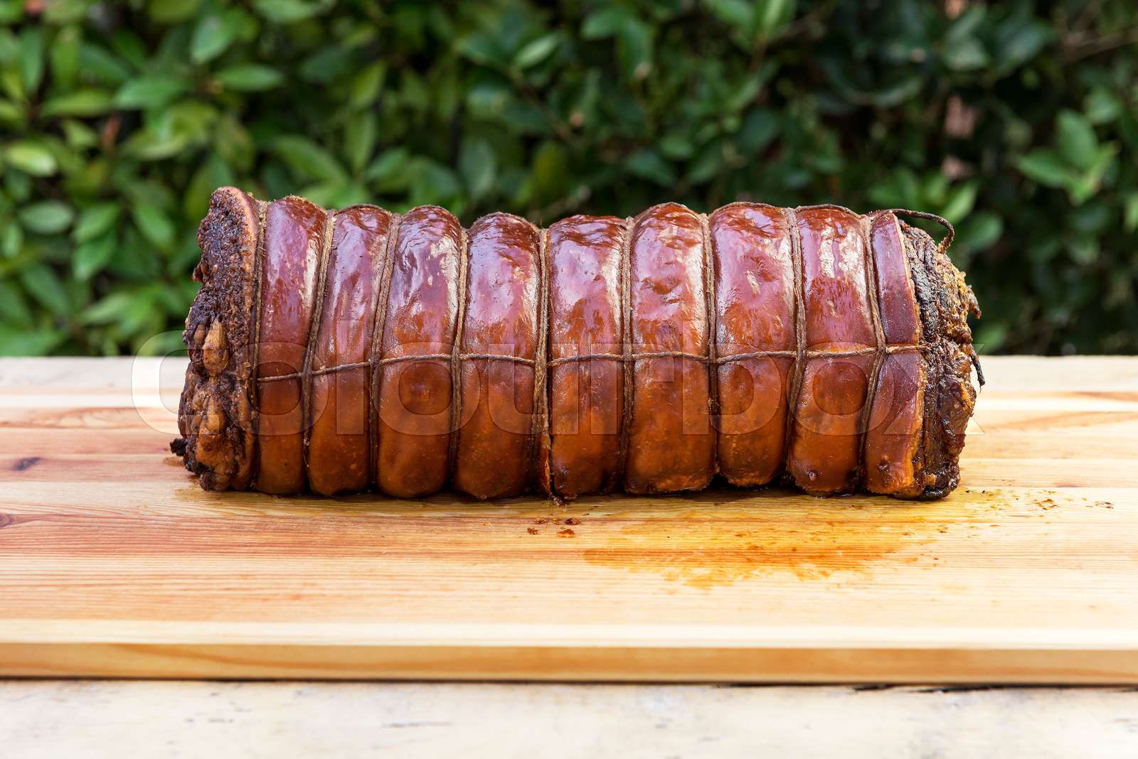 Whole Cooked roasted rolled pork on chopping board | Stock image ...