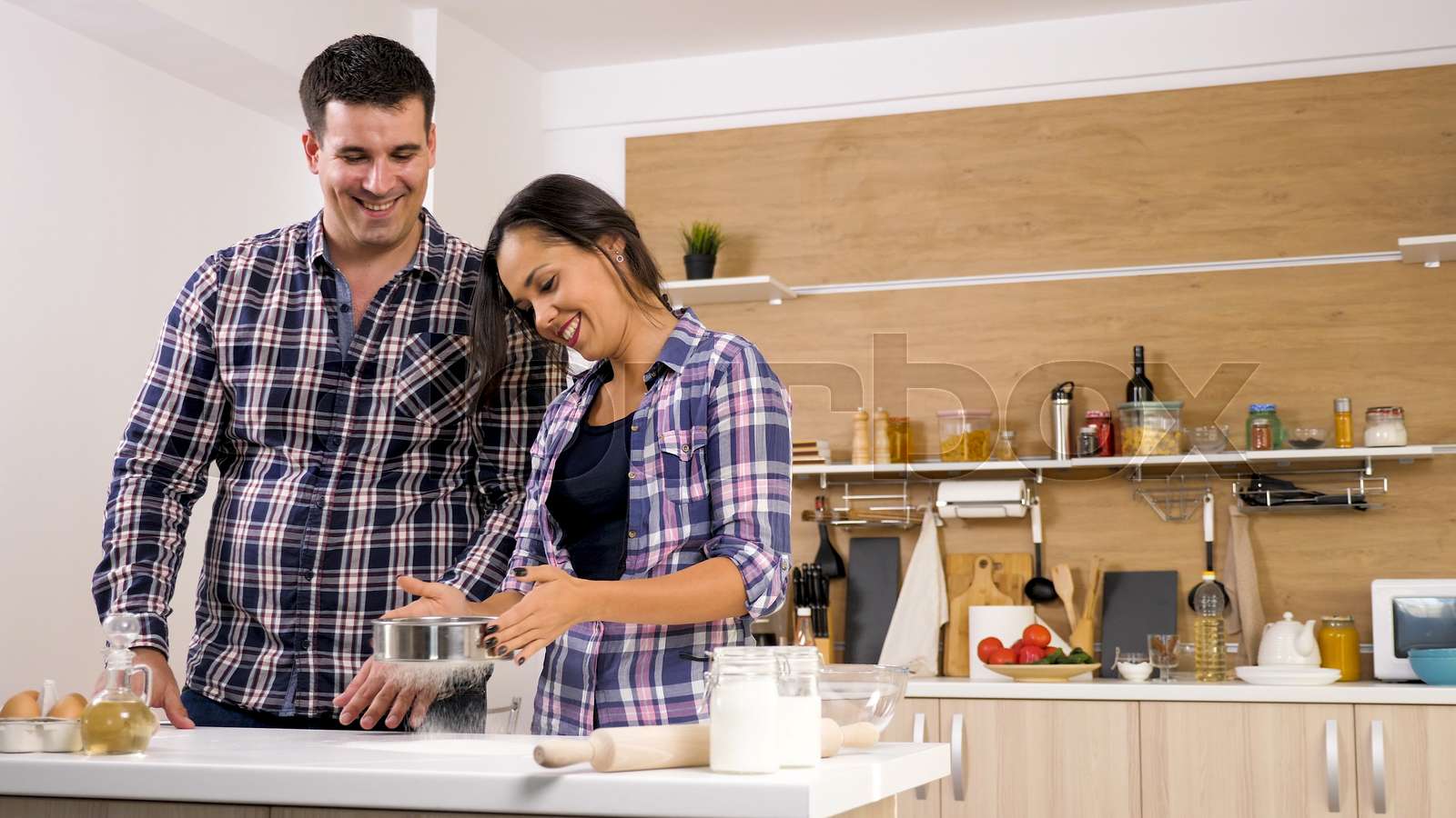 Husband helping his beautiful wife with dinner | Stock image | Colourbox