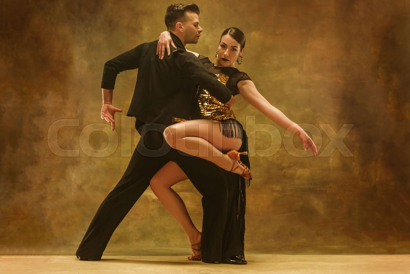 Dance ballroom couple in gold dress dancing on studio background ...
