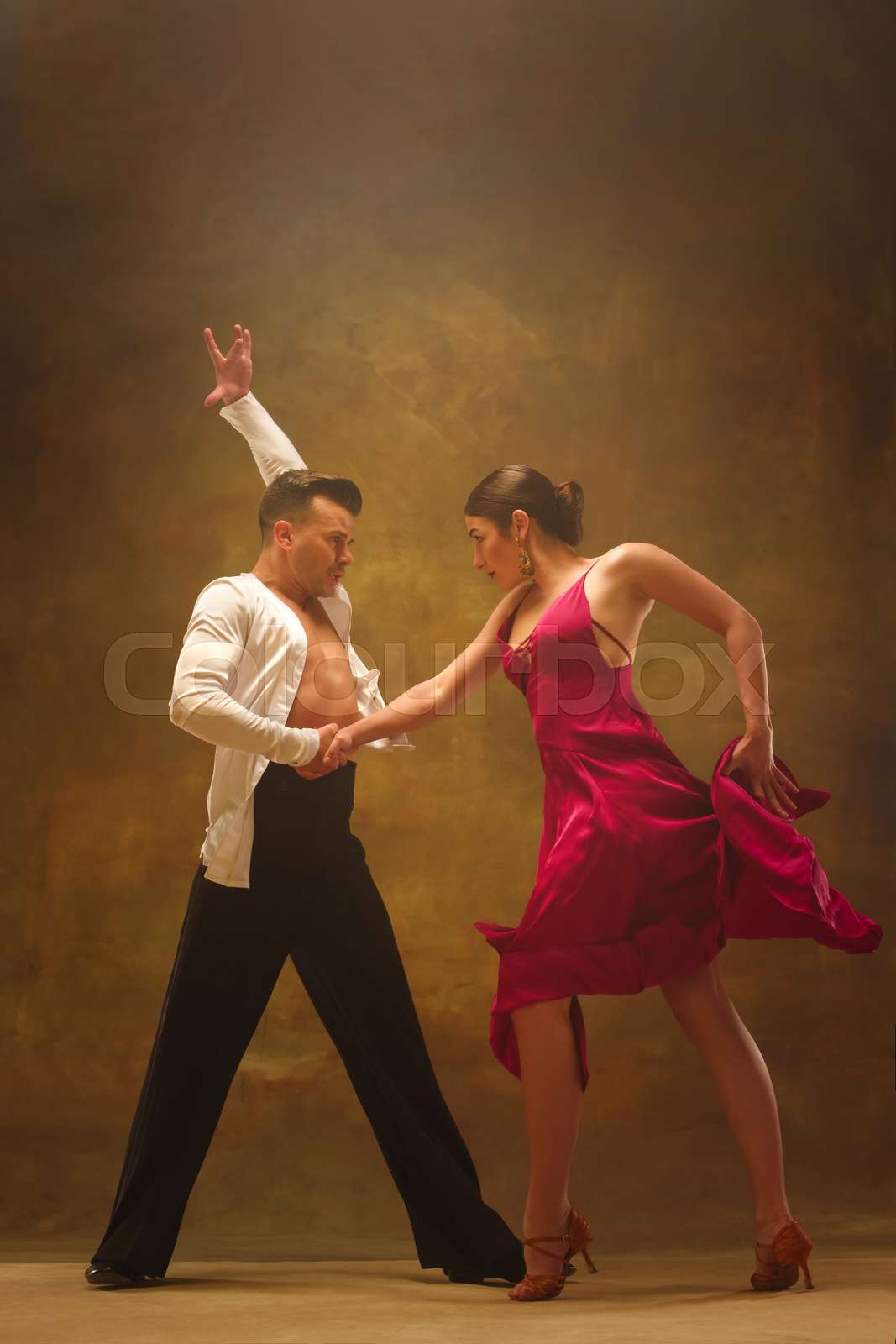 Dance ballroom couple in gold dress dancing on studio background ...