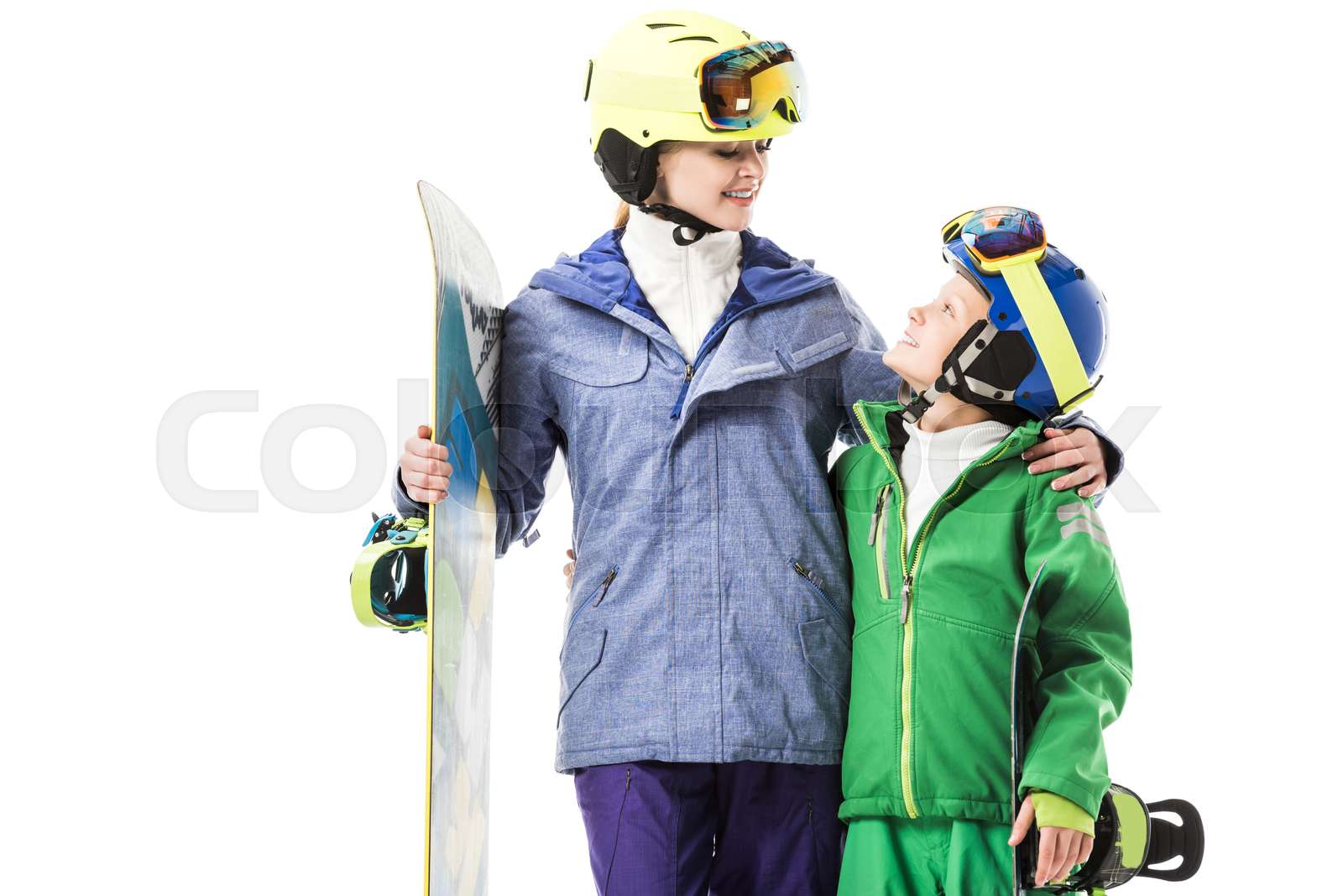 Smiling Adult Mother With Snowboard Hugging Preteen Son In Snowsuit