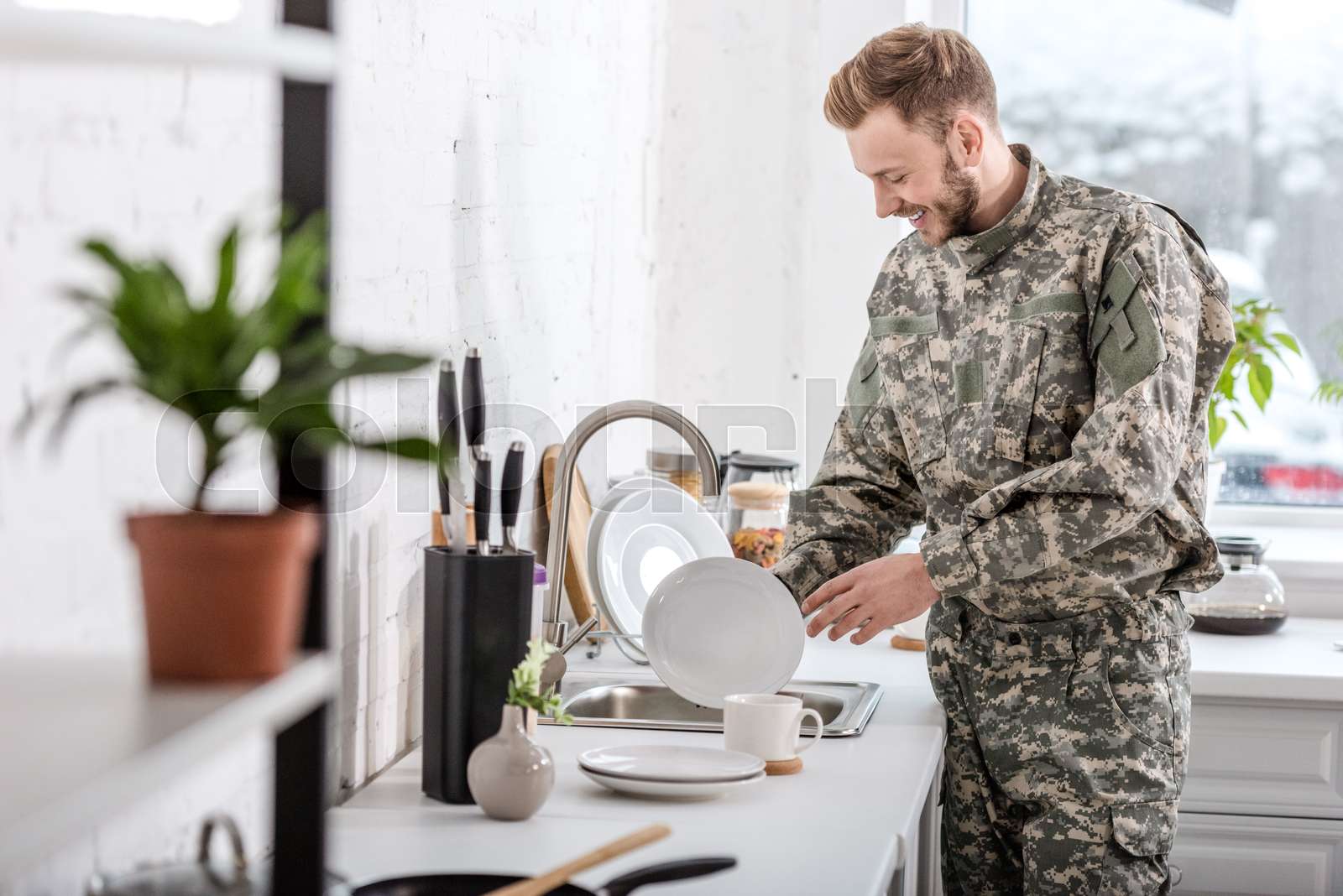 army soldier cleaning dishes in kitchen | Stock image | Colourbox