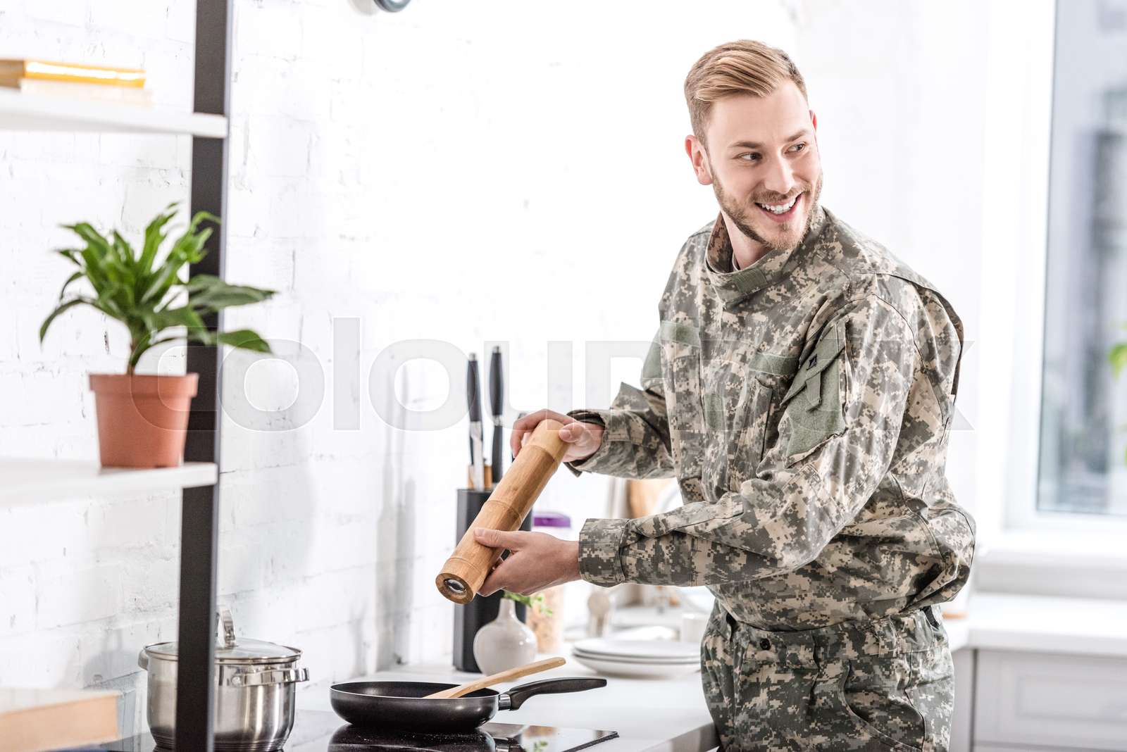 army soldier using pepper pot while cooking in kitchen | Stock image ...