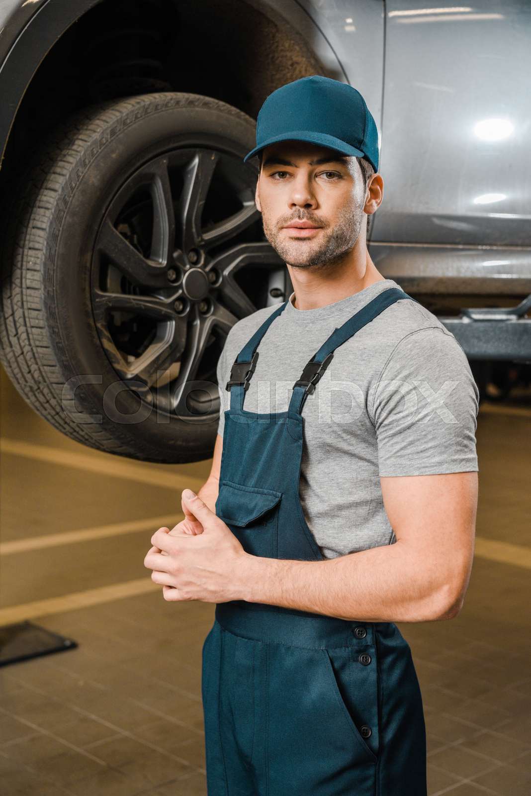 handsome male auto mechanic in working overall posing near car at ...