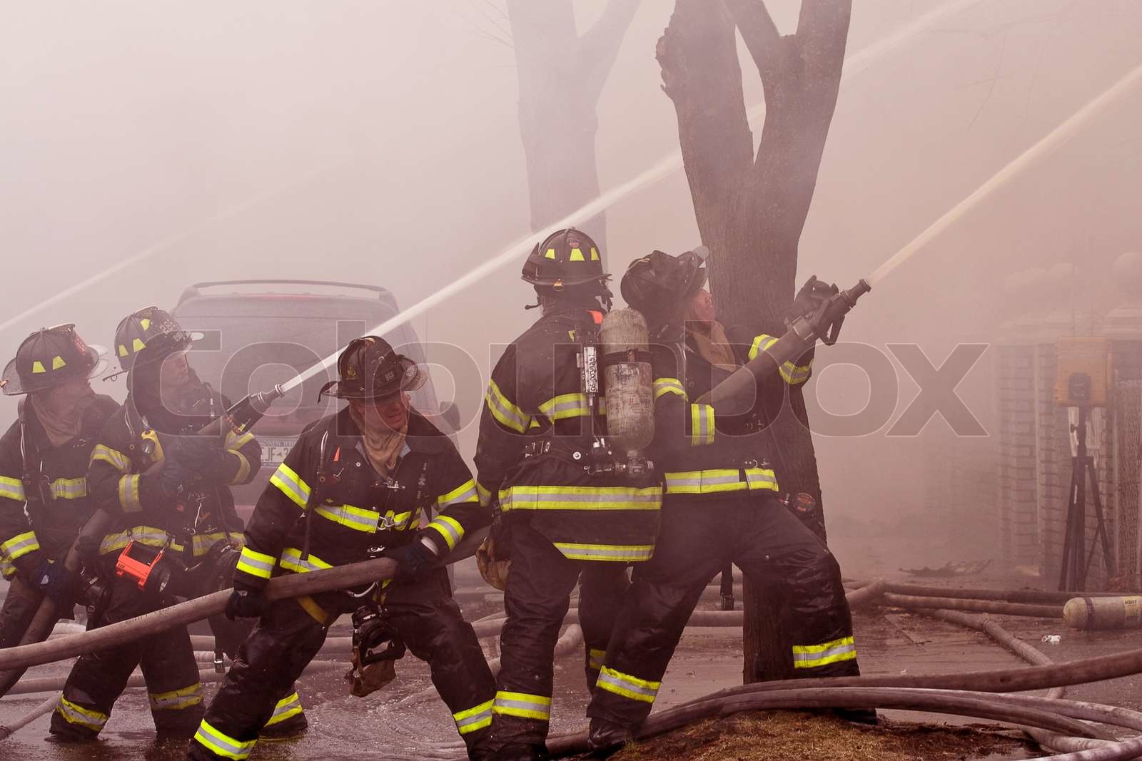 Firemen at work putting out a house fire | Stock image | Colourbox