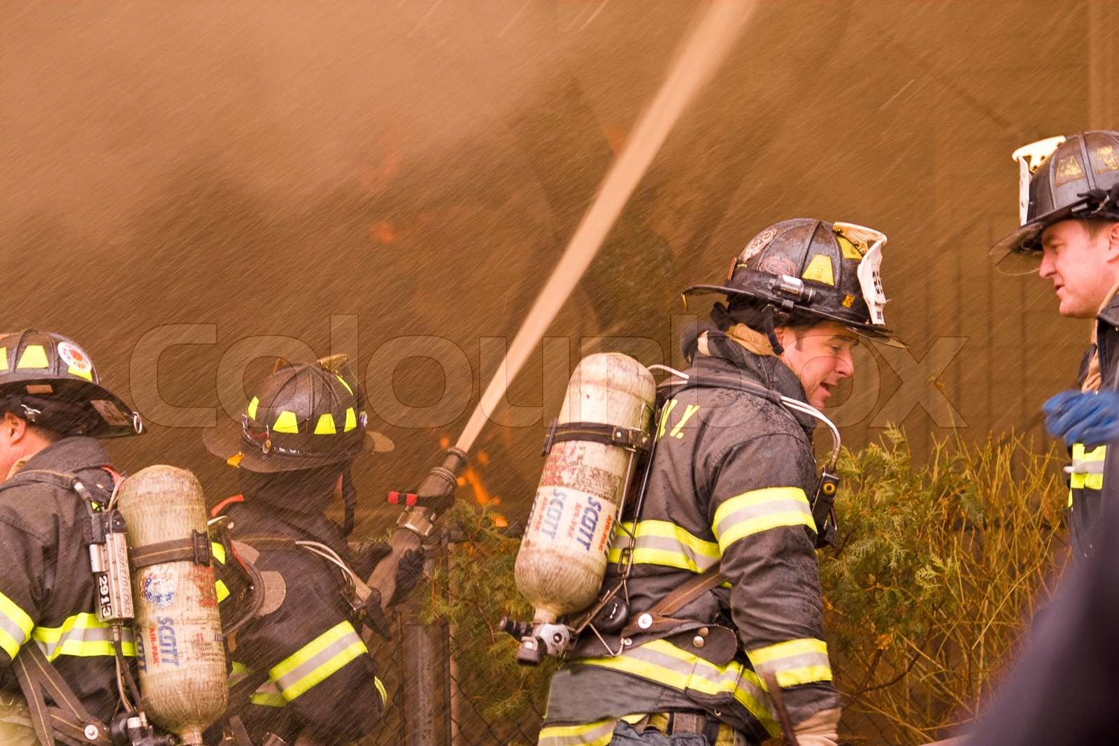 Firemen at work putting out a house fire | Stock image | Colourbox