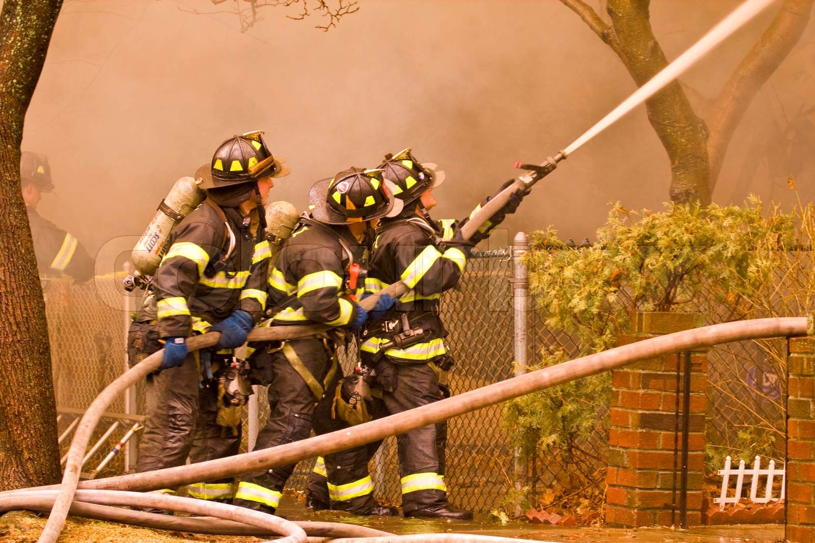 Firemen at work putting out a house fire | Stock image | Colourbox