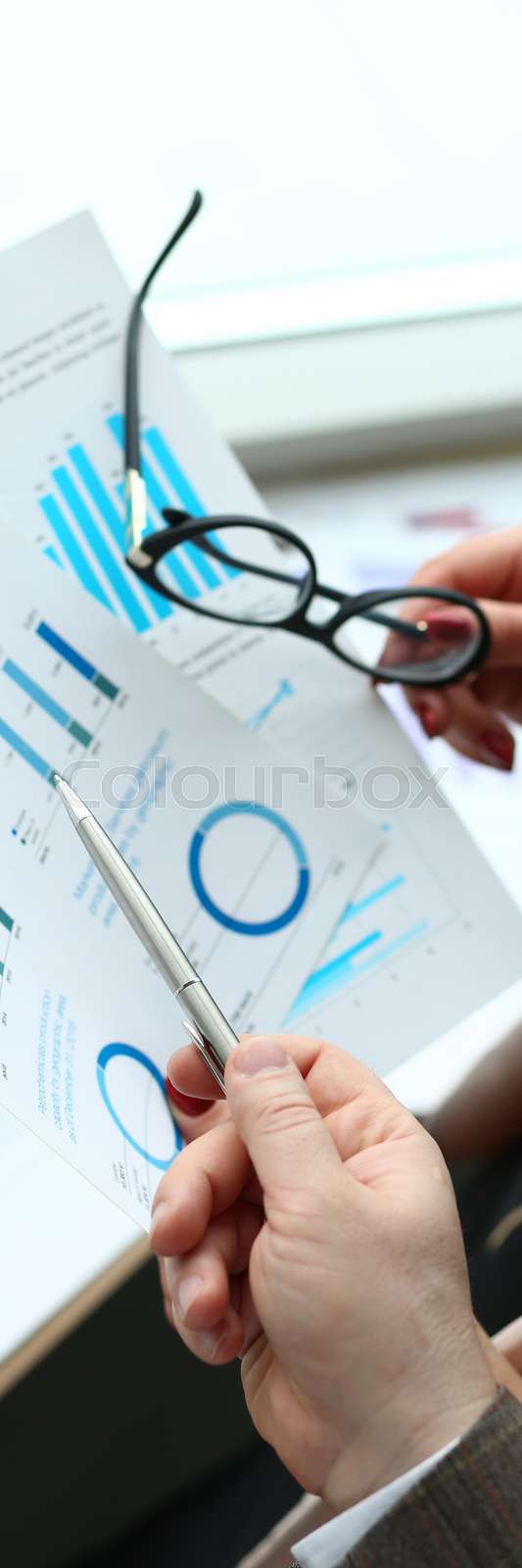 Businessman and businesswoman review graph | Stock image | Colourbox