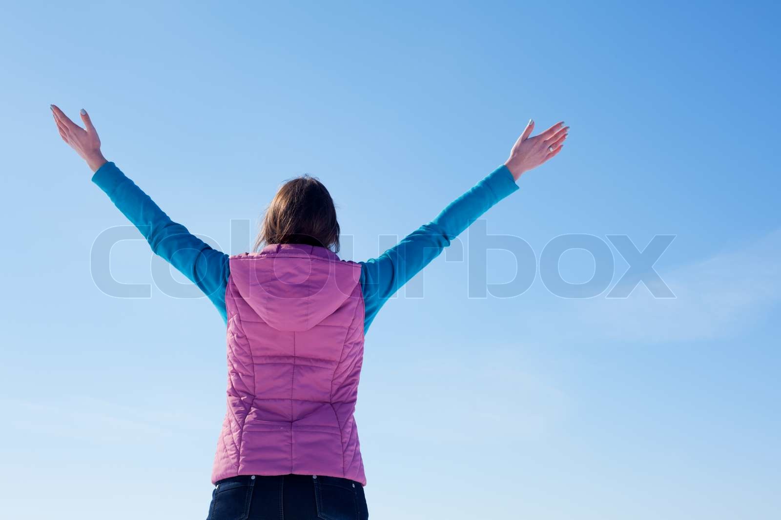 Teen girl staying with raised hands | Stock image | Colourbox