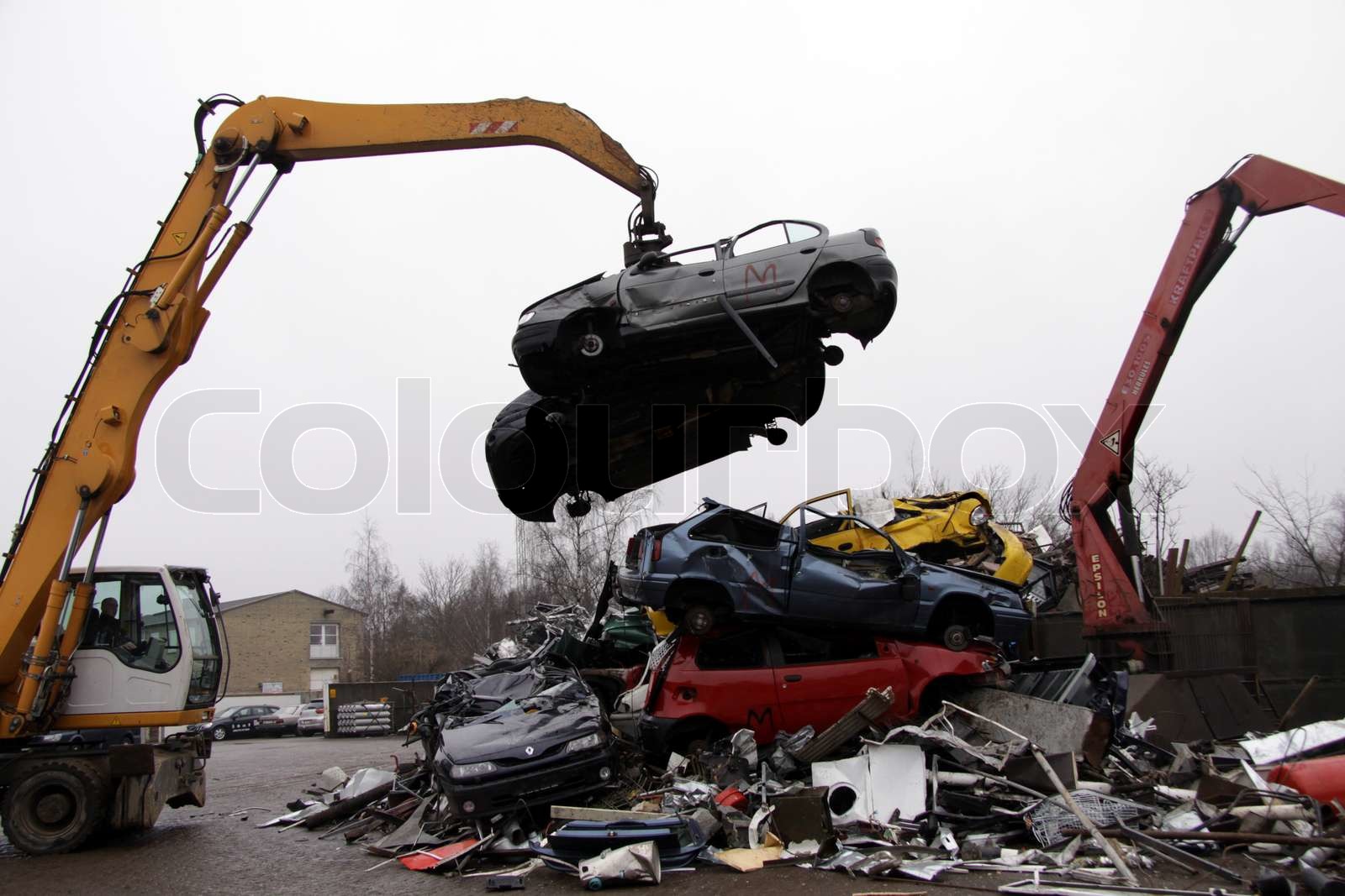 Car wreck being lifted by grab crane to be scrapped with other cars and ...