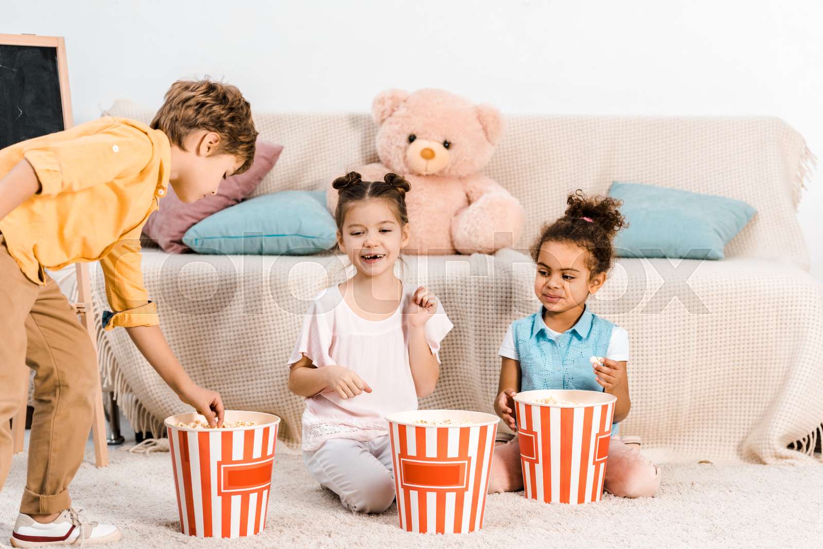 adorable multiethnic kids eating popcorn together | Stock image | Colourbox