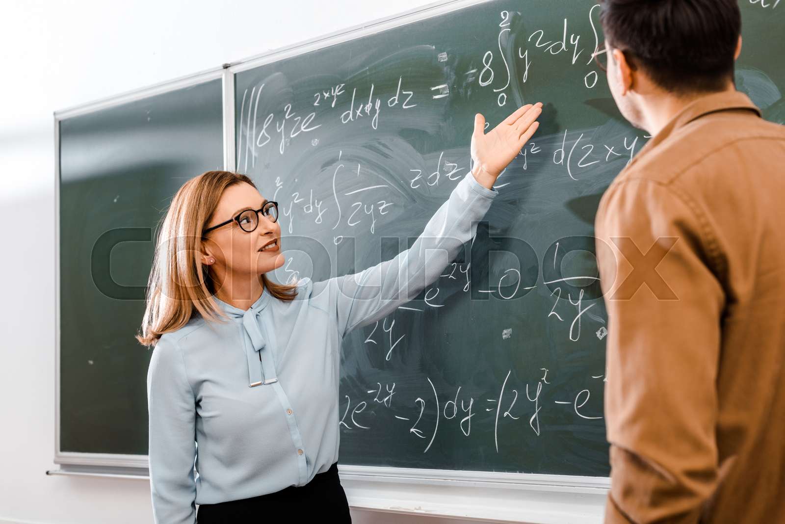 Female professor showing equations in classroom | Stock image | Colourbox