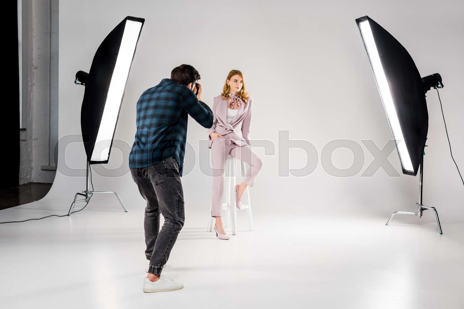 back view of photographer shooting beautiful young female model in ...