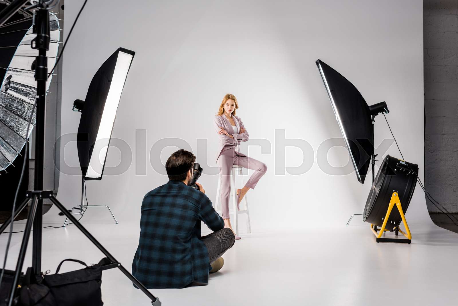 back view of young photographer shooting beautiful female model in ...
