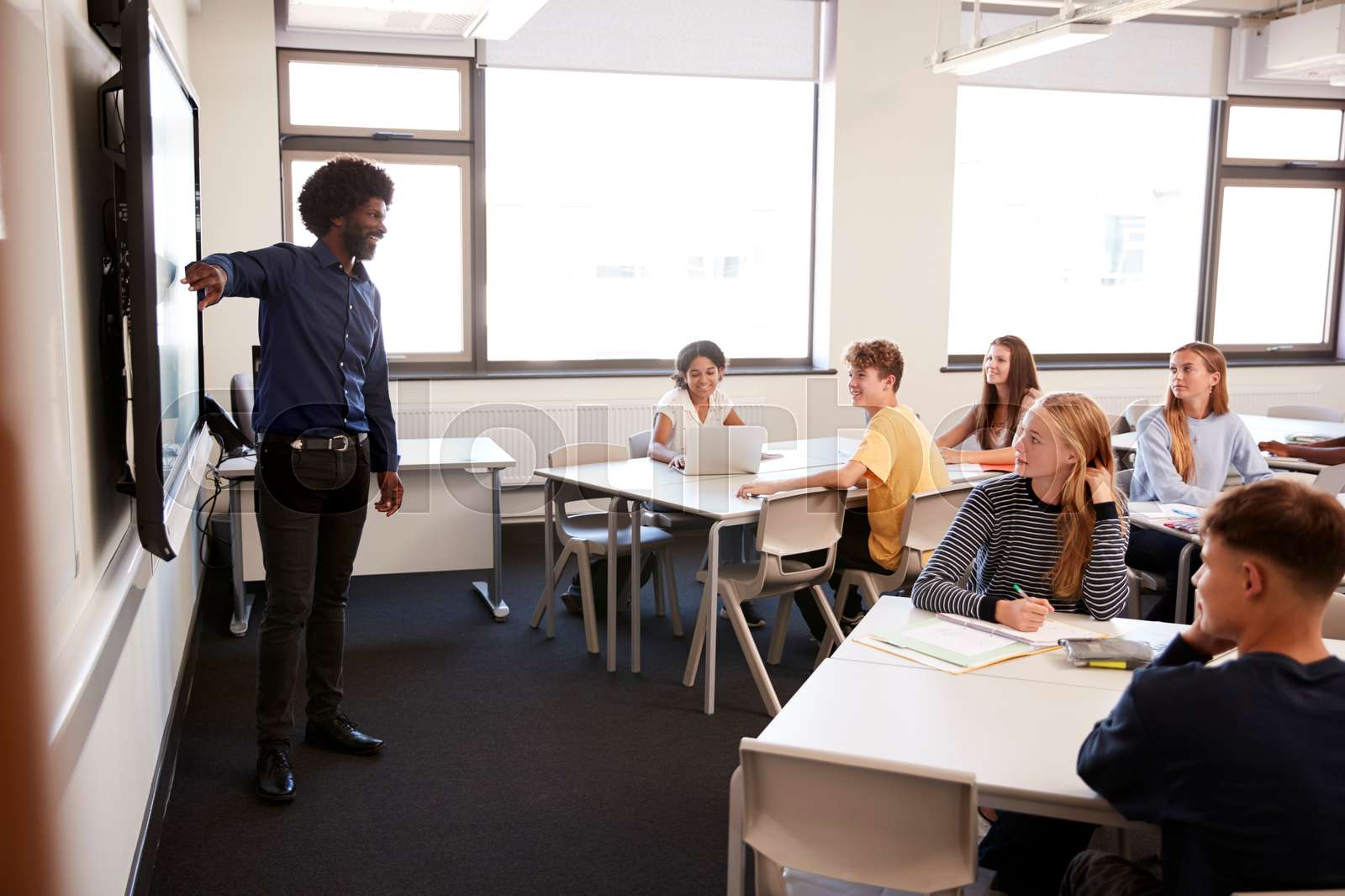 Male High School Teacher Standing Next To Interactive Whiteboard And ...