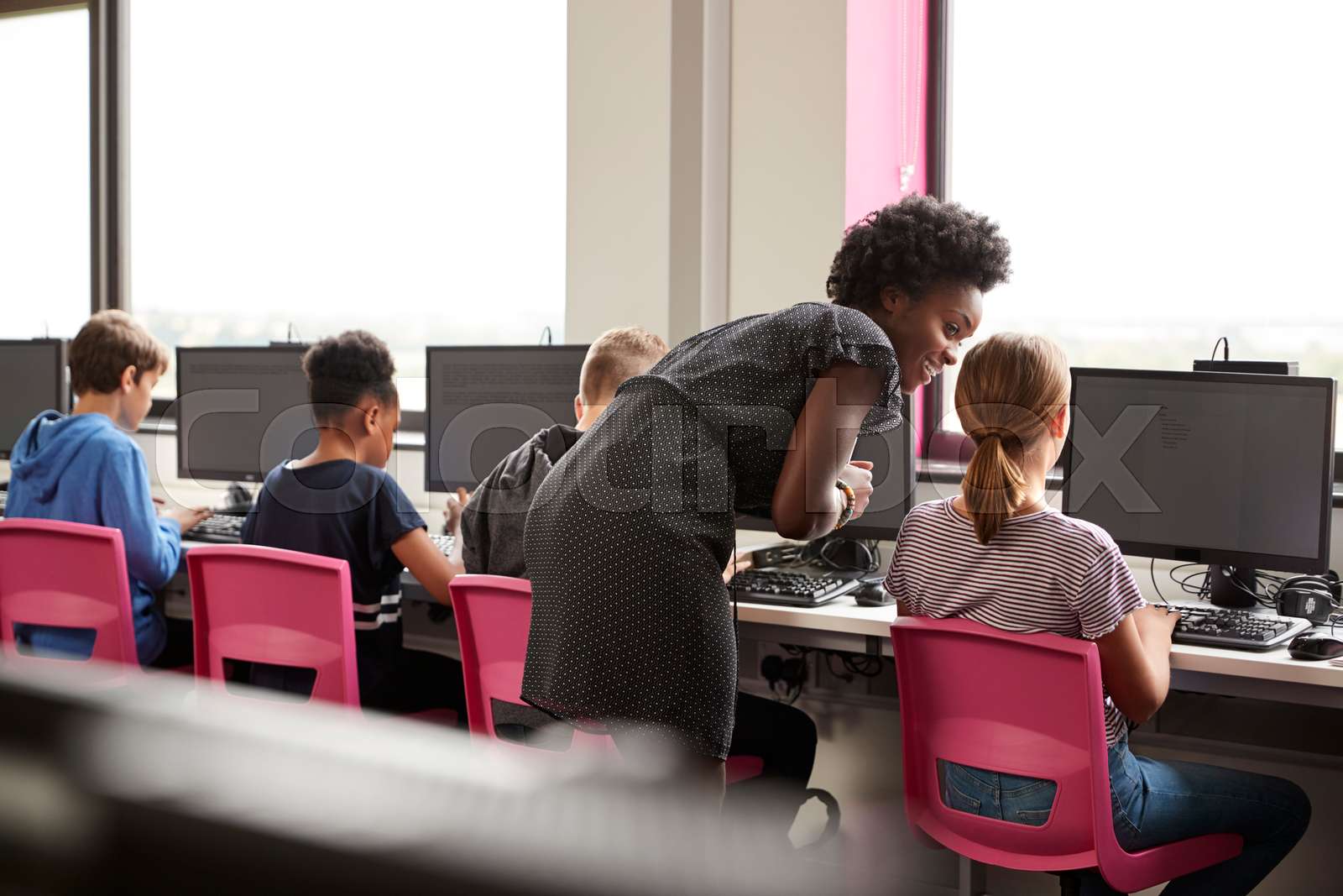 Female Teacher Supervising Line Of High School Students Working at ...