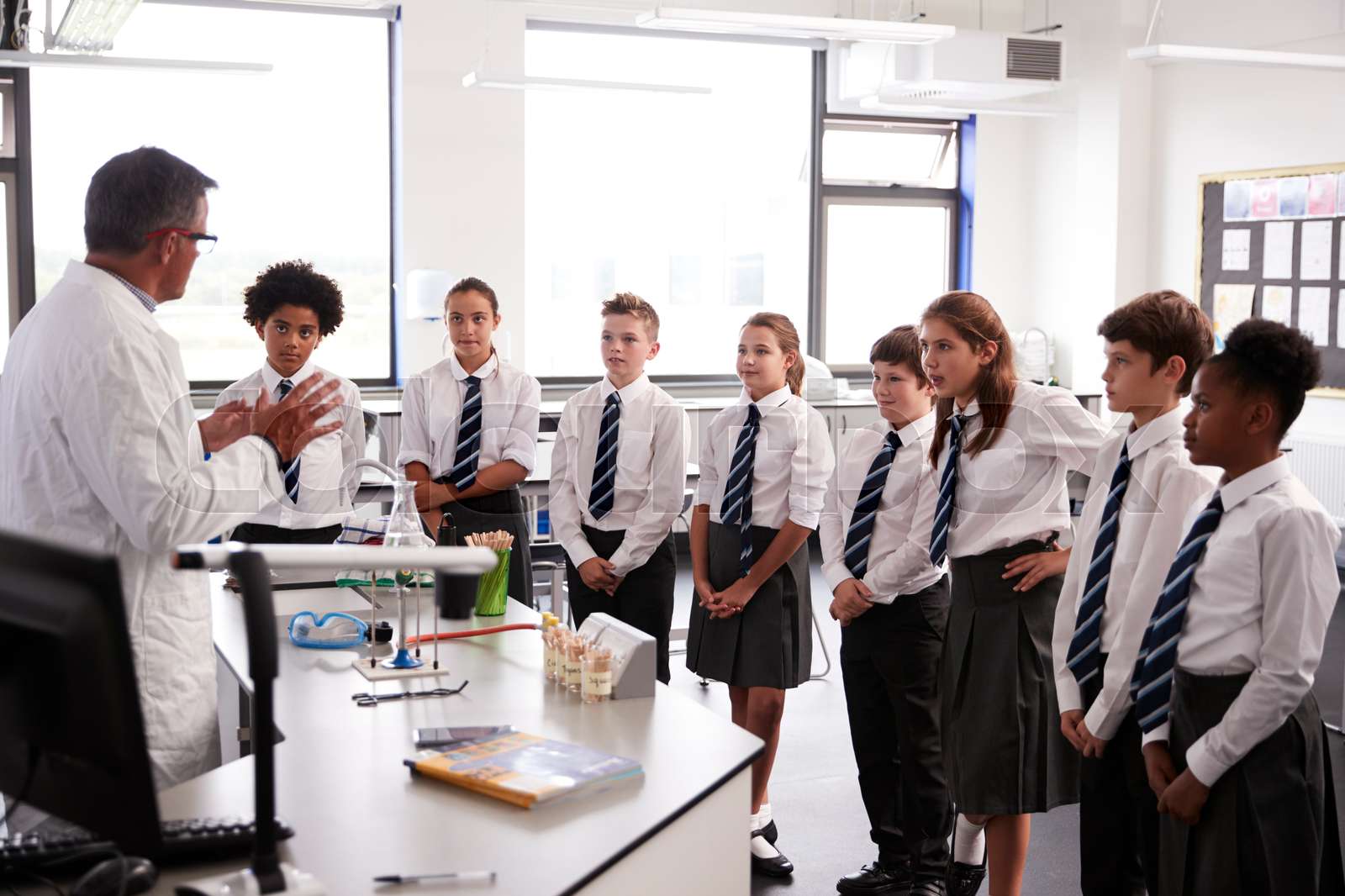 Male High School Tutor Teaching High School Students Wearing Uniforms ...
