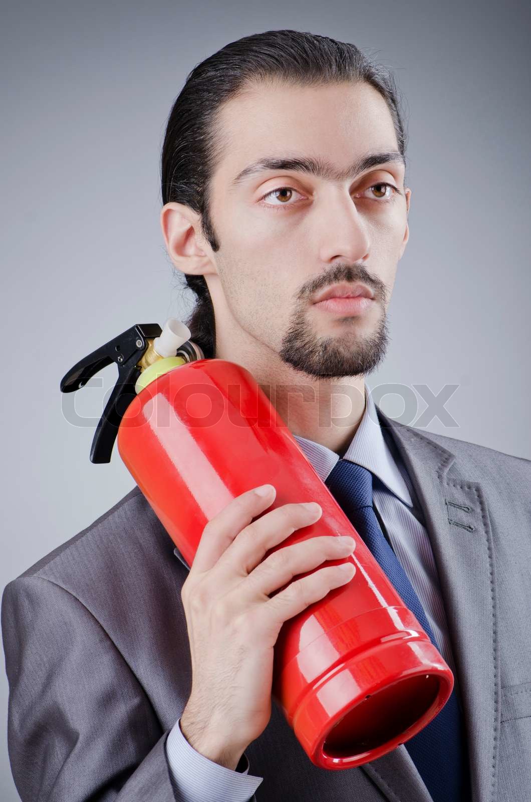 Man with fire extinguisher in firefighting concept | Stock image ...