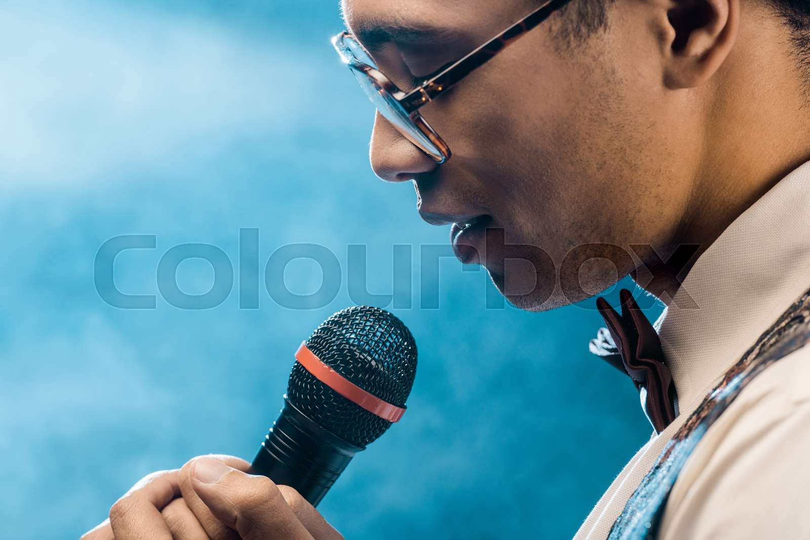 partial view of mixed race man singing in microphone on stage with ...