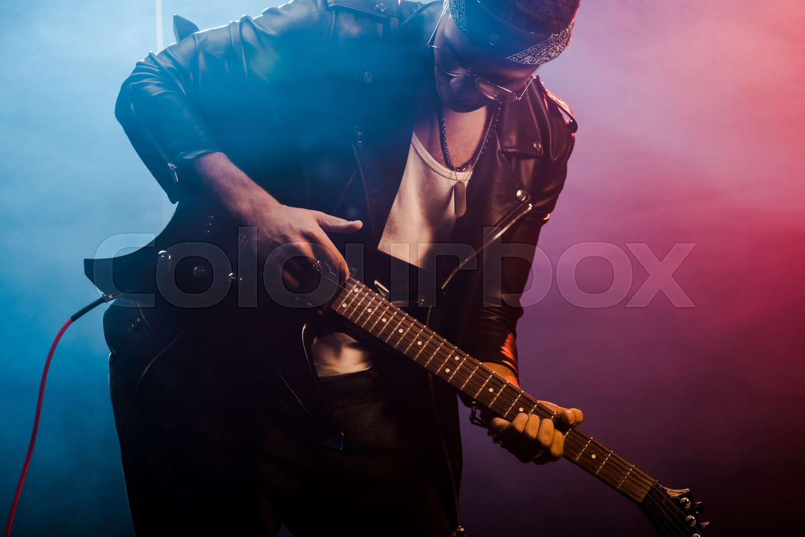 young male rocker in leather jacket performing on electric guitar on ...