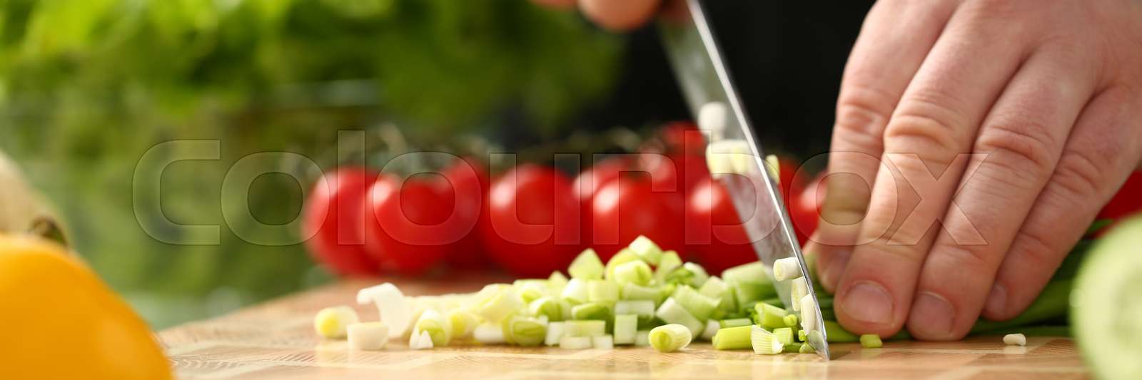Cook holds knife in hand and cuts on | Stock image | Colourbox