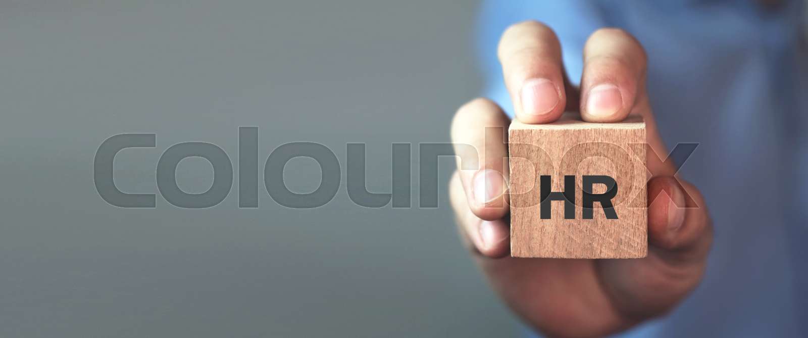 Man holding HR word on wooden cube. | Stock image | Colourbox