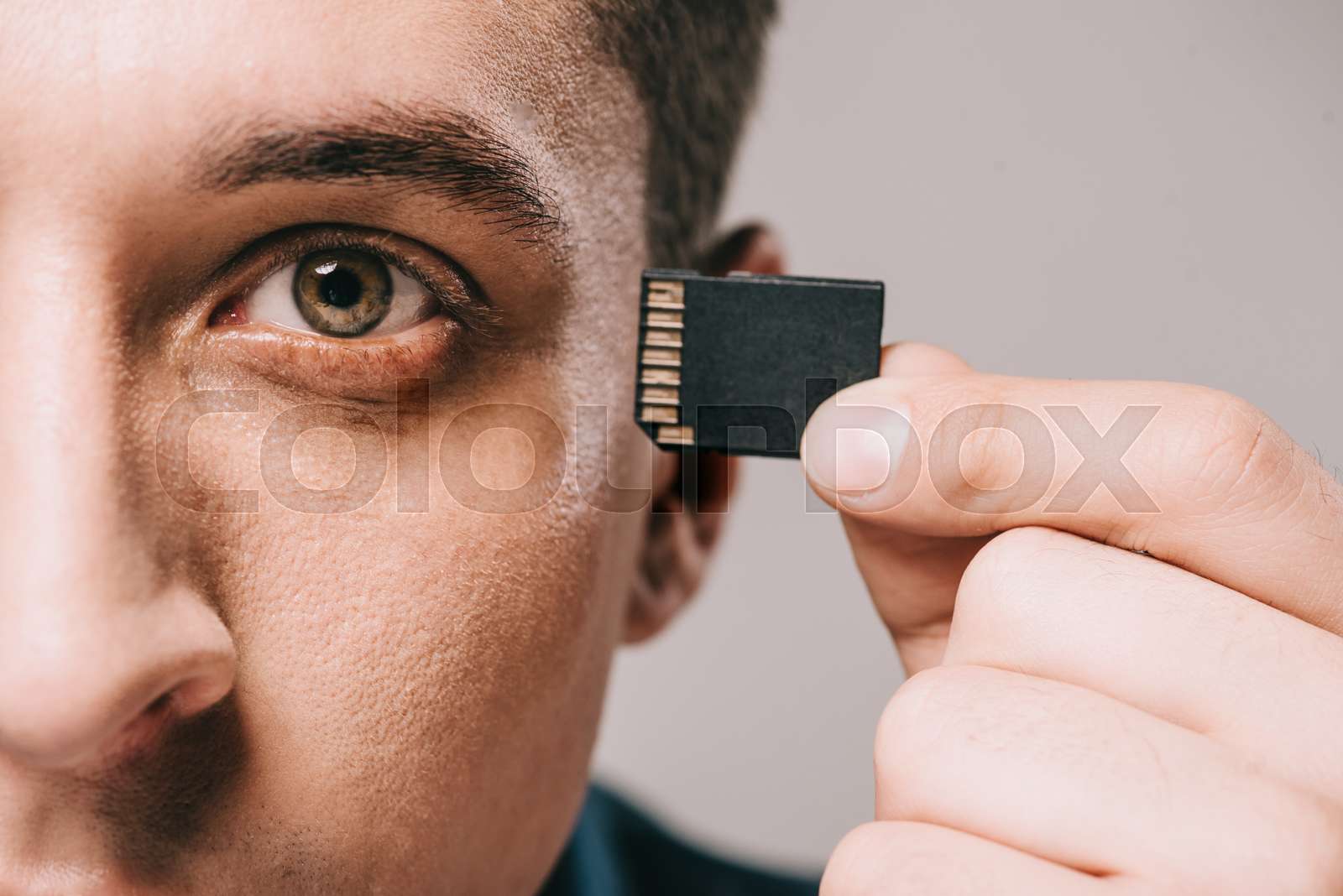 selective focus of man implanting microchip in head isolated on grey ...