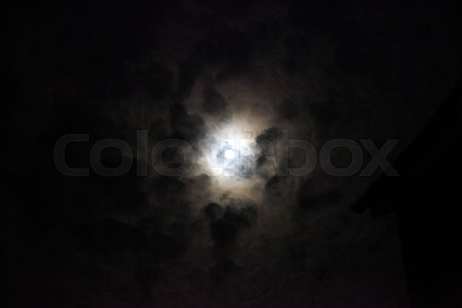 Full Moon Appearing Through Clouds At Night | Stock image | Colourbox