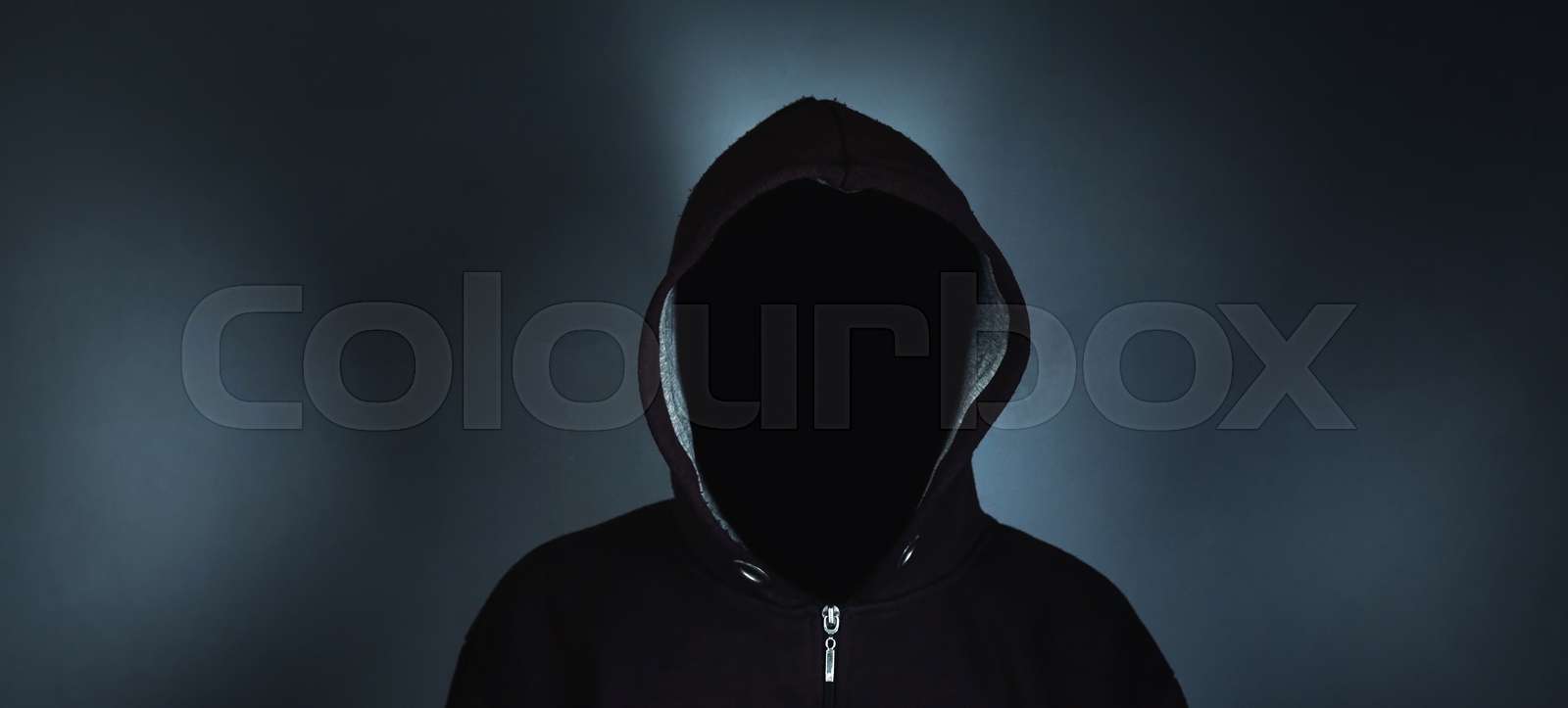 Faceless man in hoodie standing on dark background. | Stock image ...