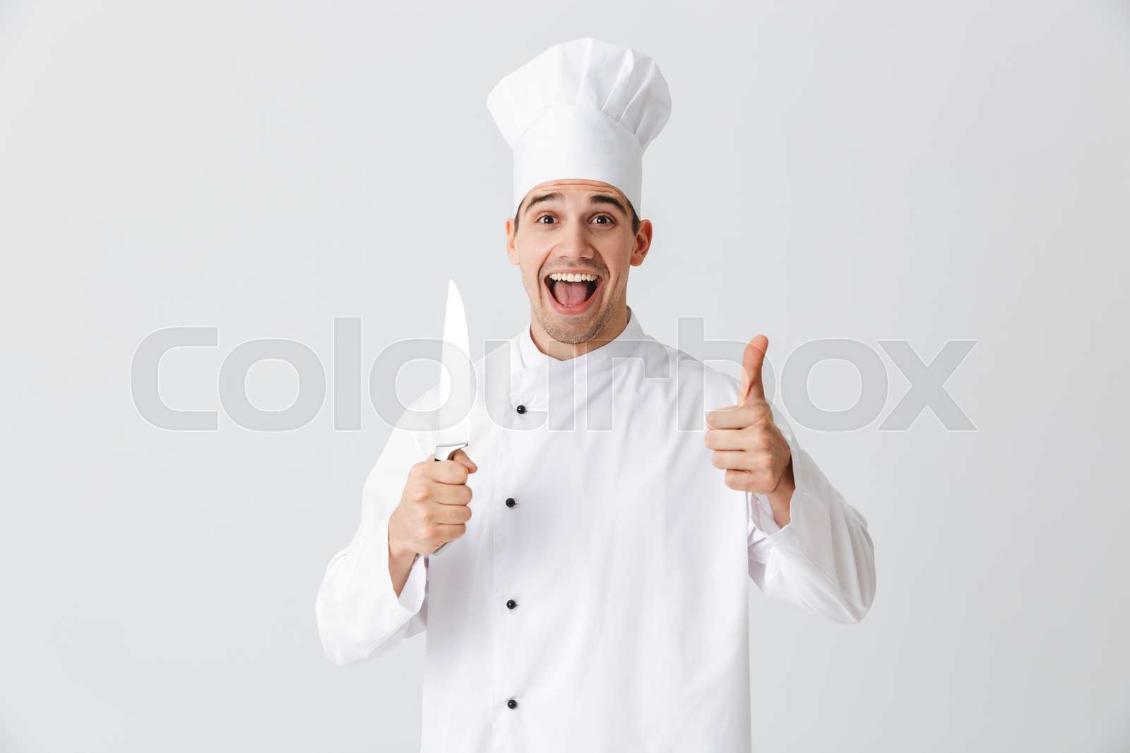 Happy chef cook wearing uniform holding a knife | Stock image | Colourbox